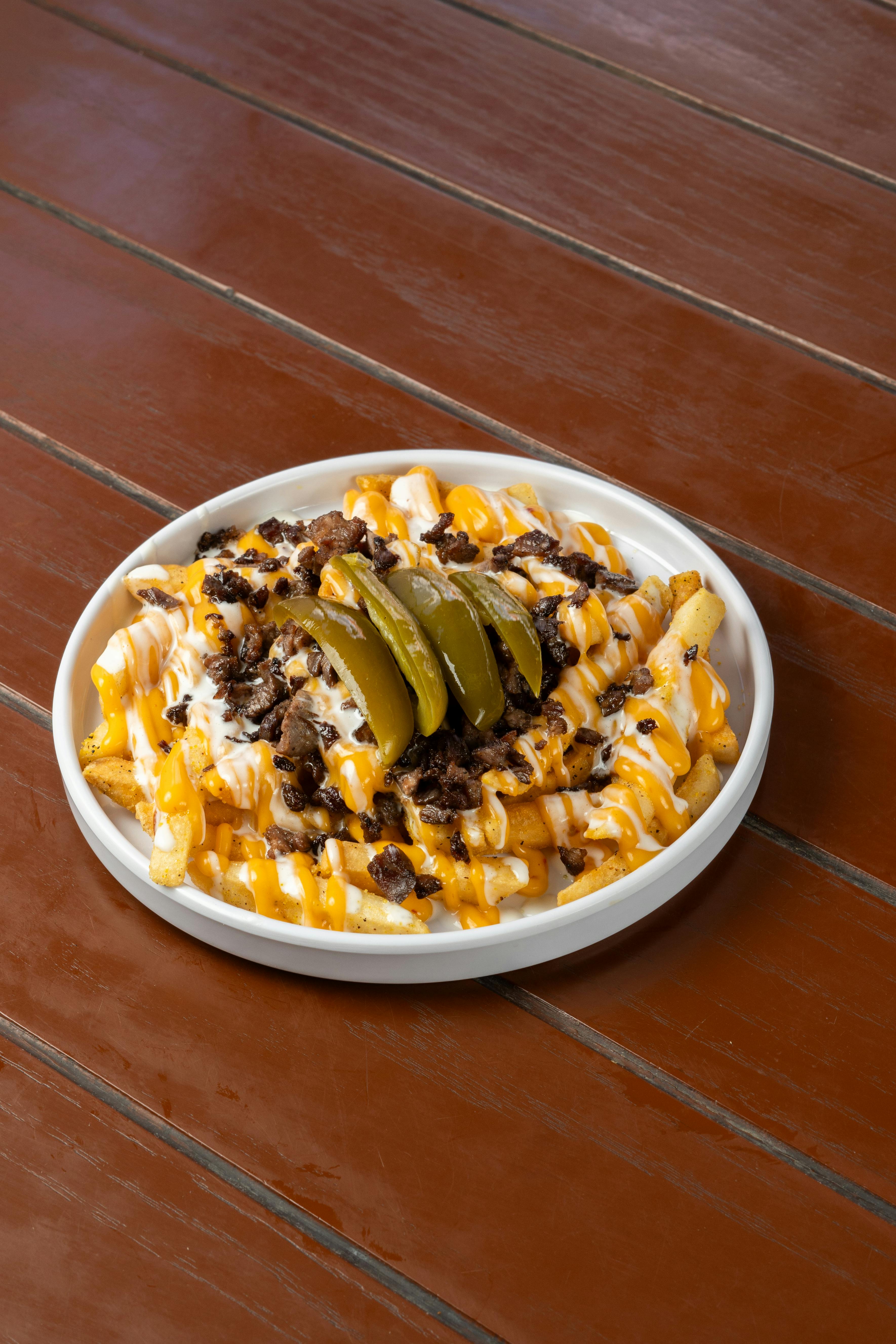 Delicious Loaded Fries with Cheese and Pickles · Free Stock Photo