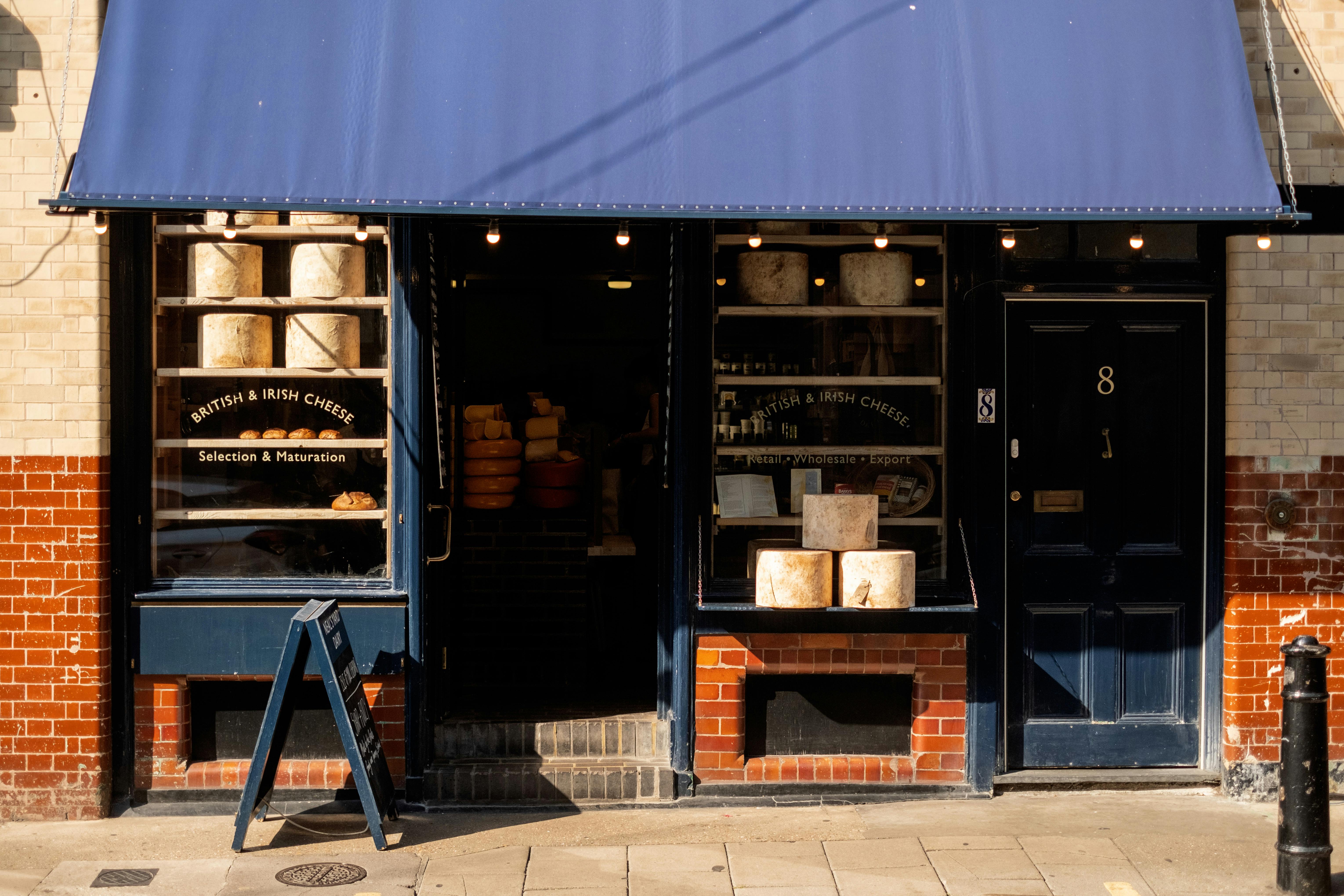 Charming Cheese Shopfront with Blue Awning · Free Stock Photo