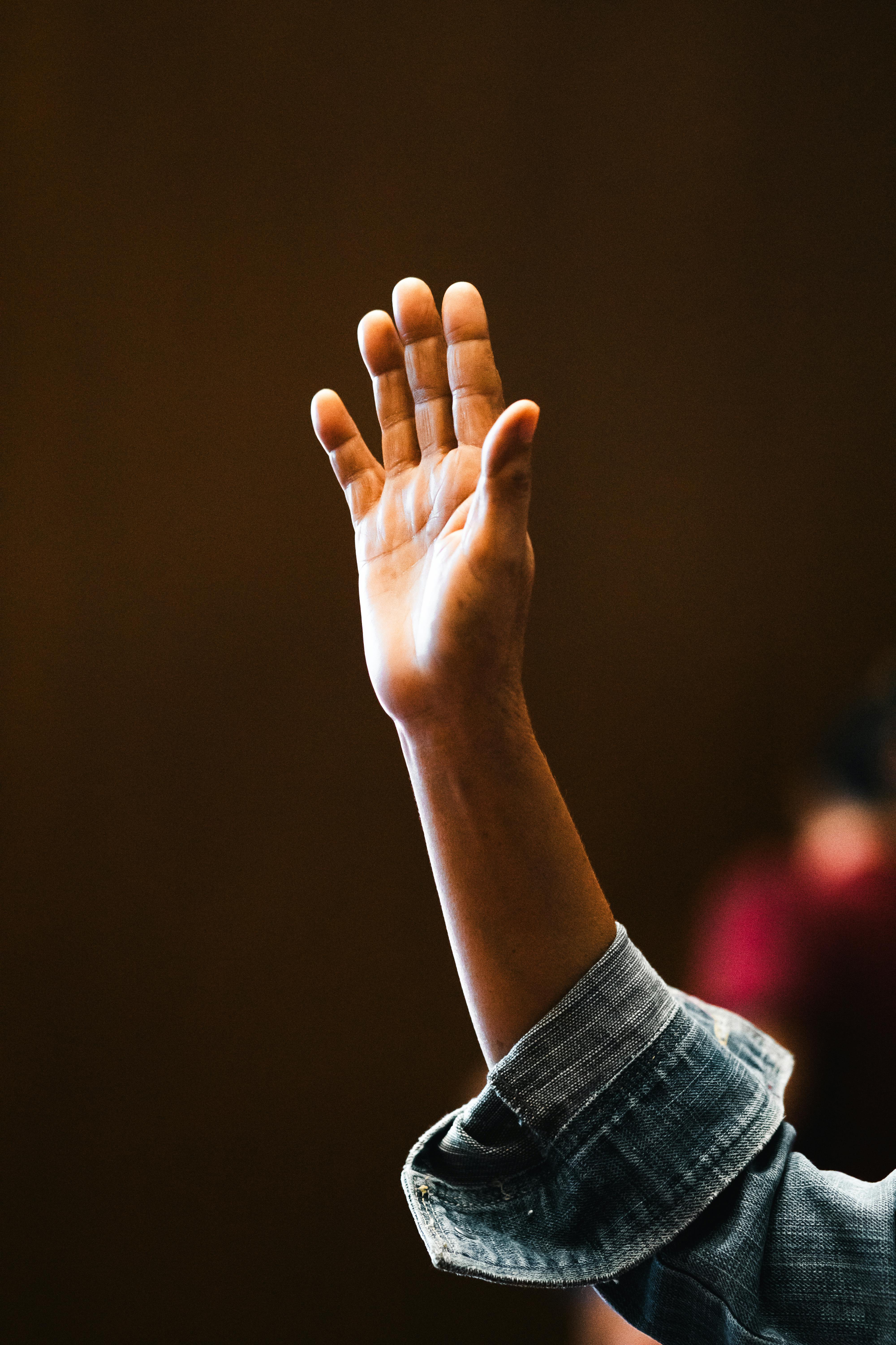 Raised Hand in Worship Indoor Setting · Free Stock Photo