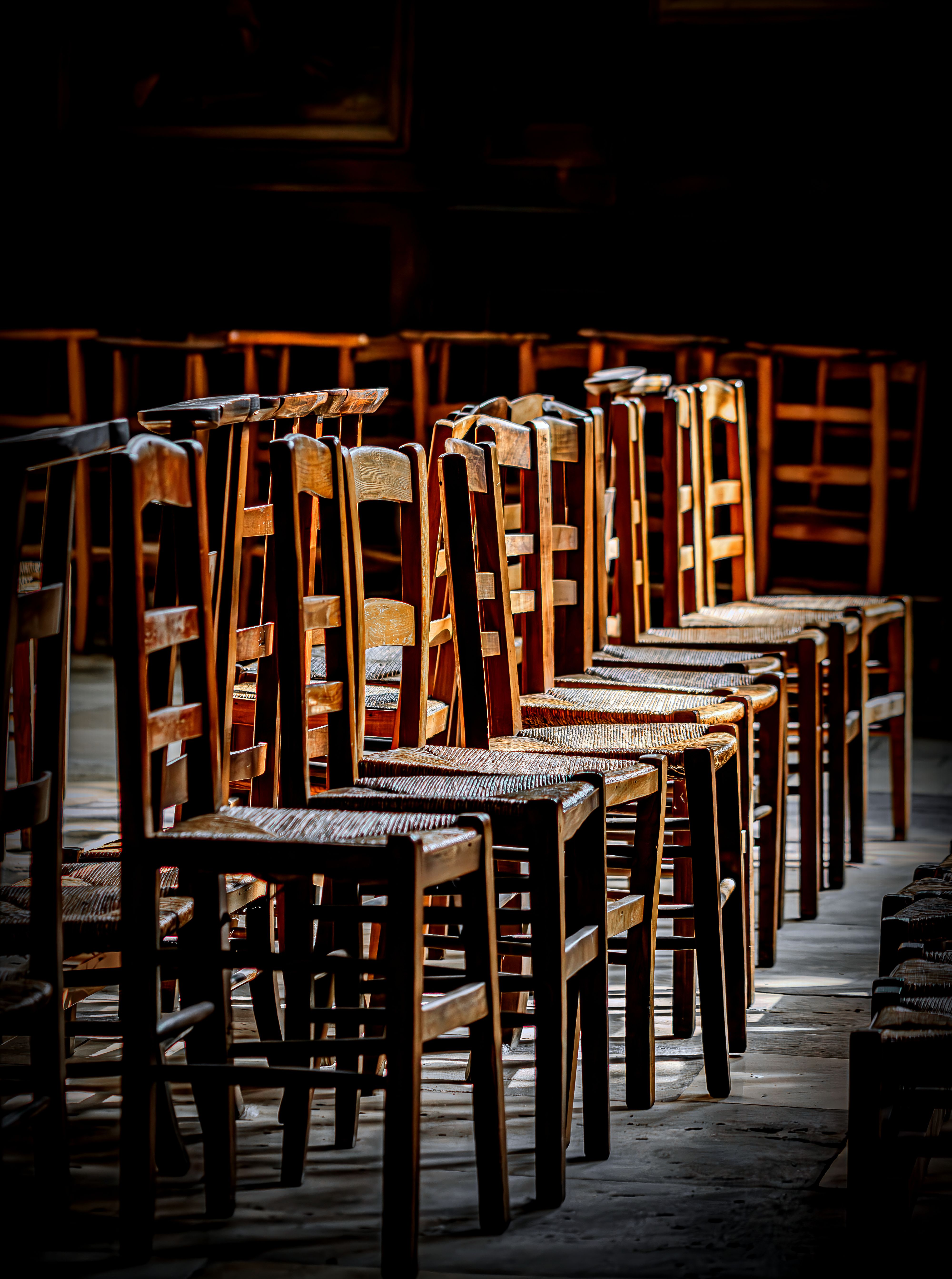 Rows of Wooden Chairs in Dimly Lit Room · Free Stock Photo
