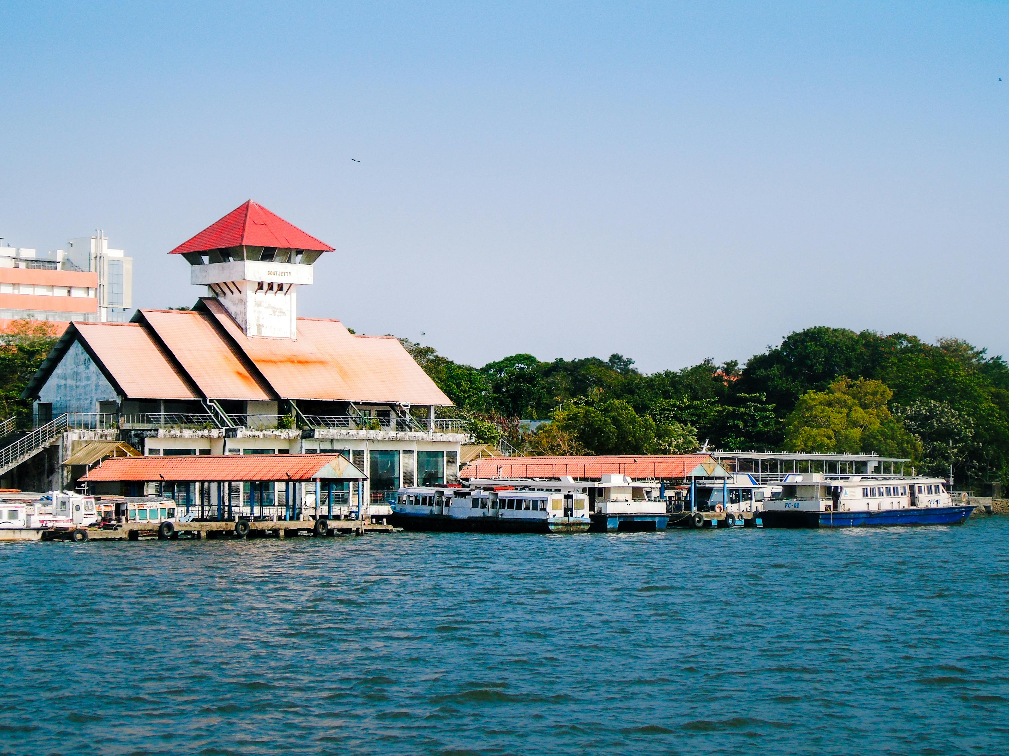 Scenic Waterfront with Red Roof Building · Free Stock Photo