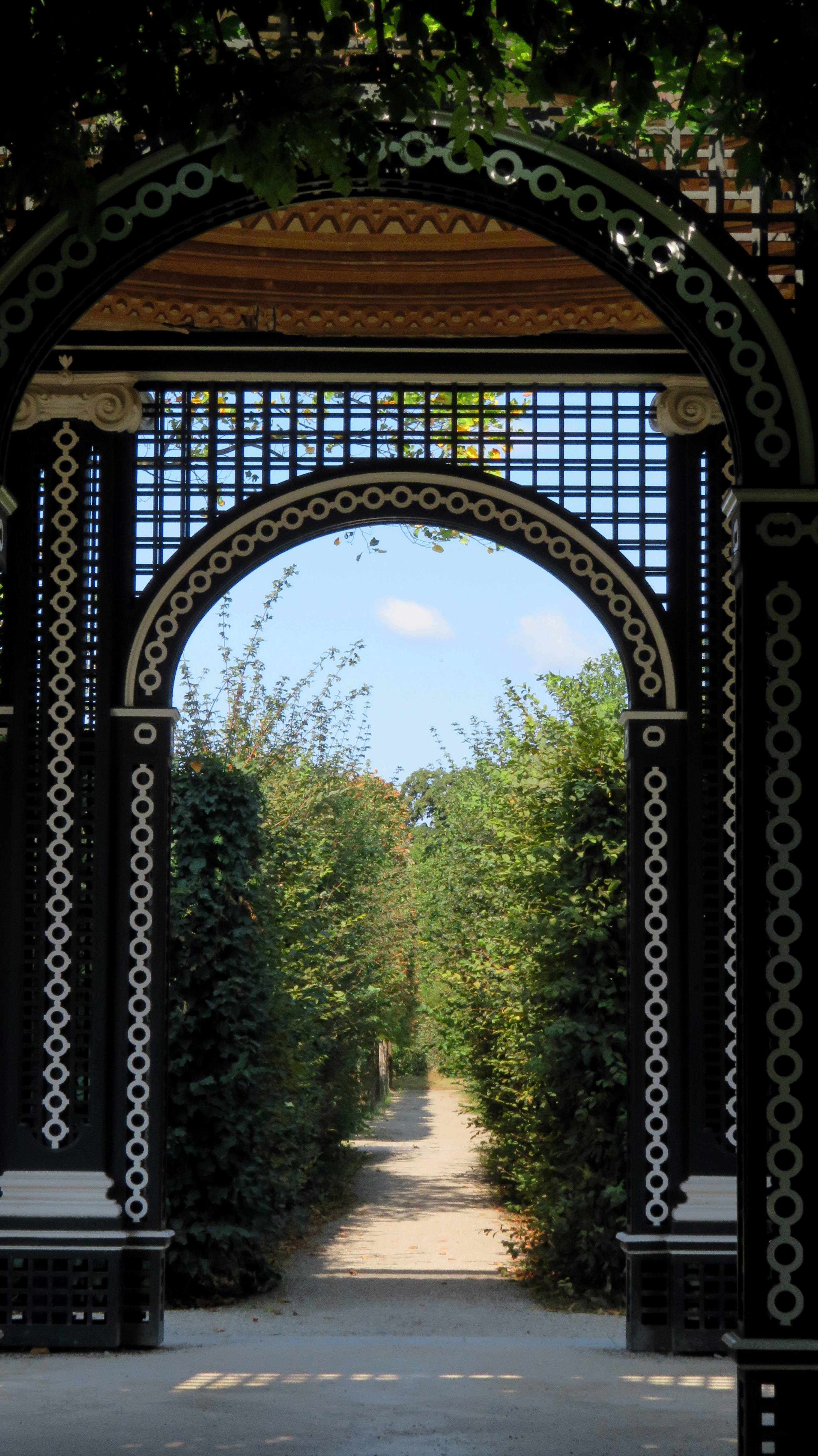 Ornate Garden Archway Framing Scenic Pathway · Free Stock Photo