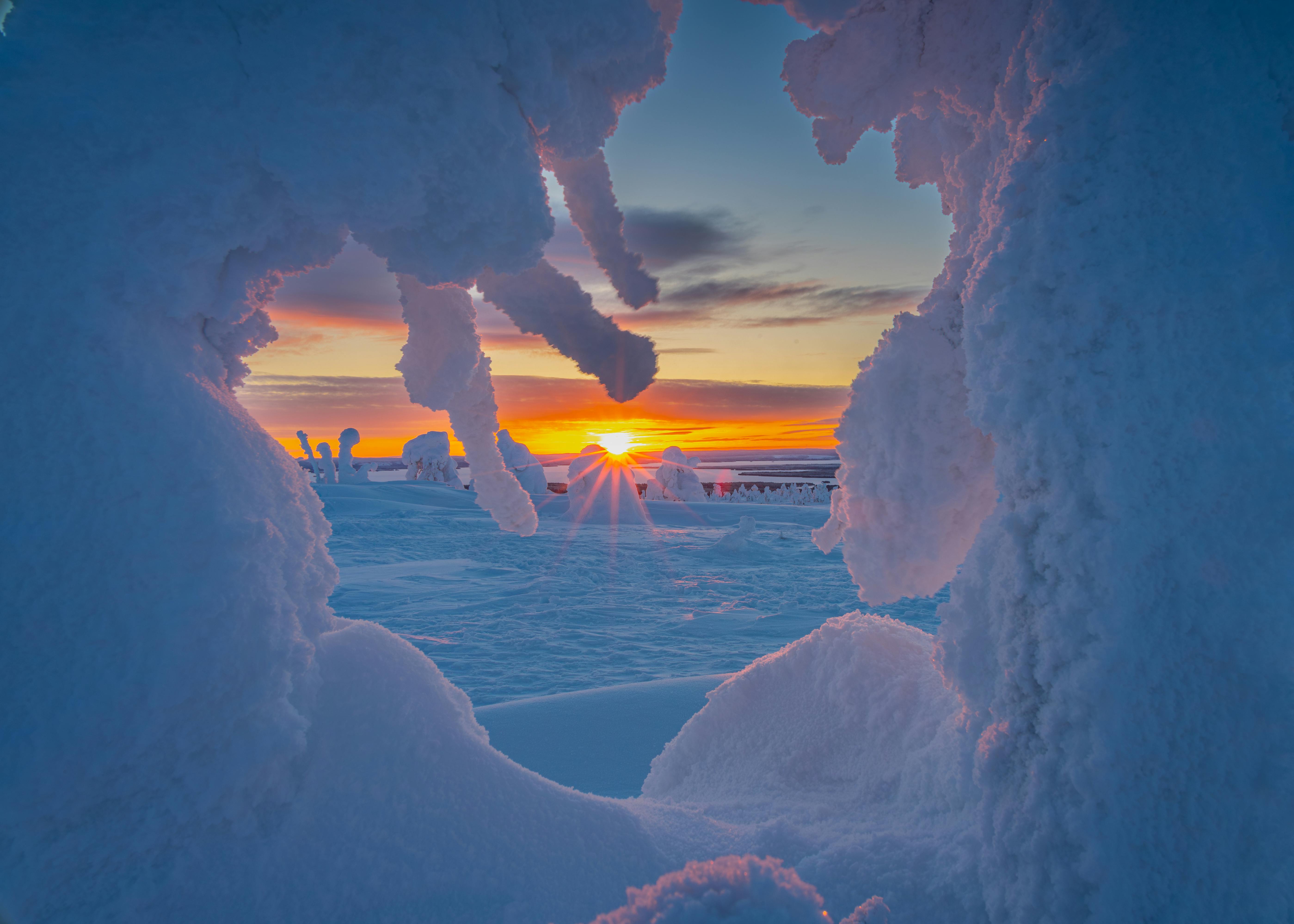 Enchanting Snowy Sunset Through Ice Formations · Free Stock Photo