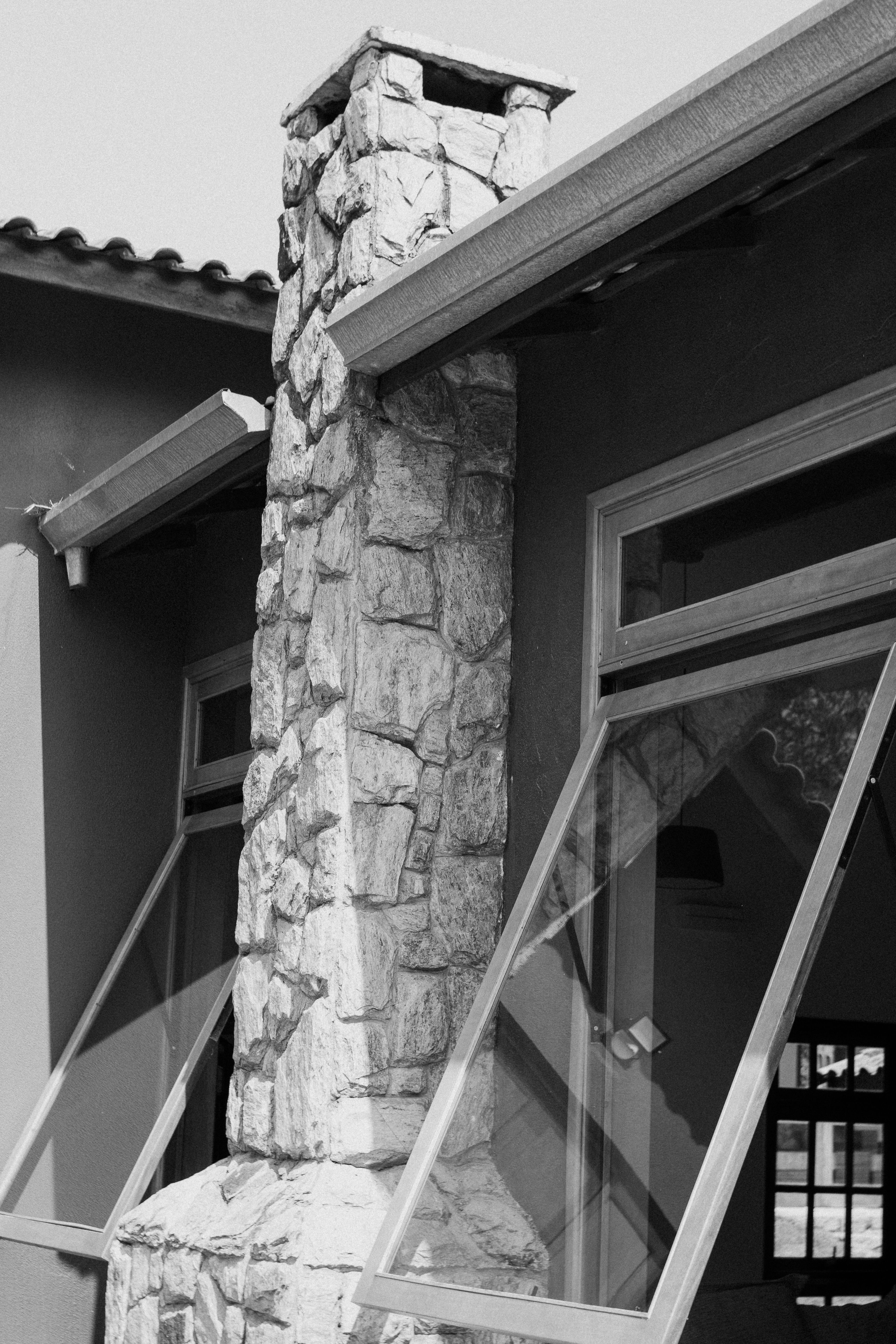 Stone Chimney Exterior with Large Windows · Free Stock Photo
