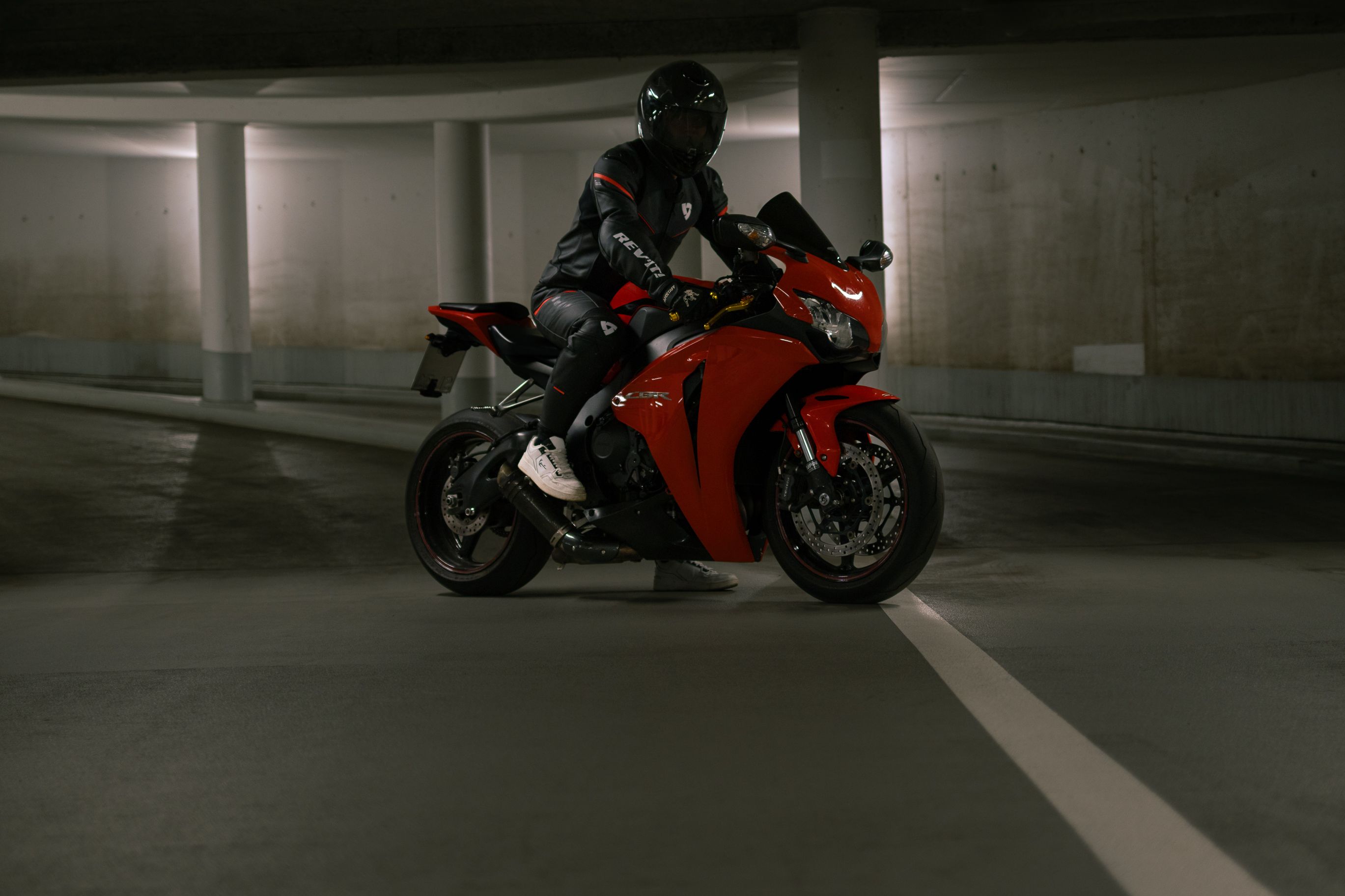 Motociclista En Motocicleta Deportiva Roja En Un Garaje Con Poca Luz ...