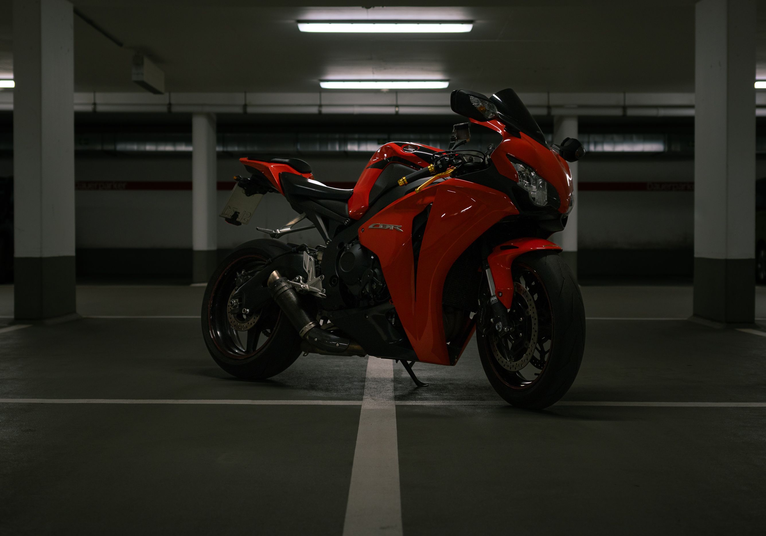 Striking Red Motorcycle in Dimly Lit Parking Garage · Free Stock Photo