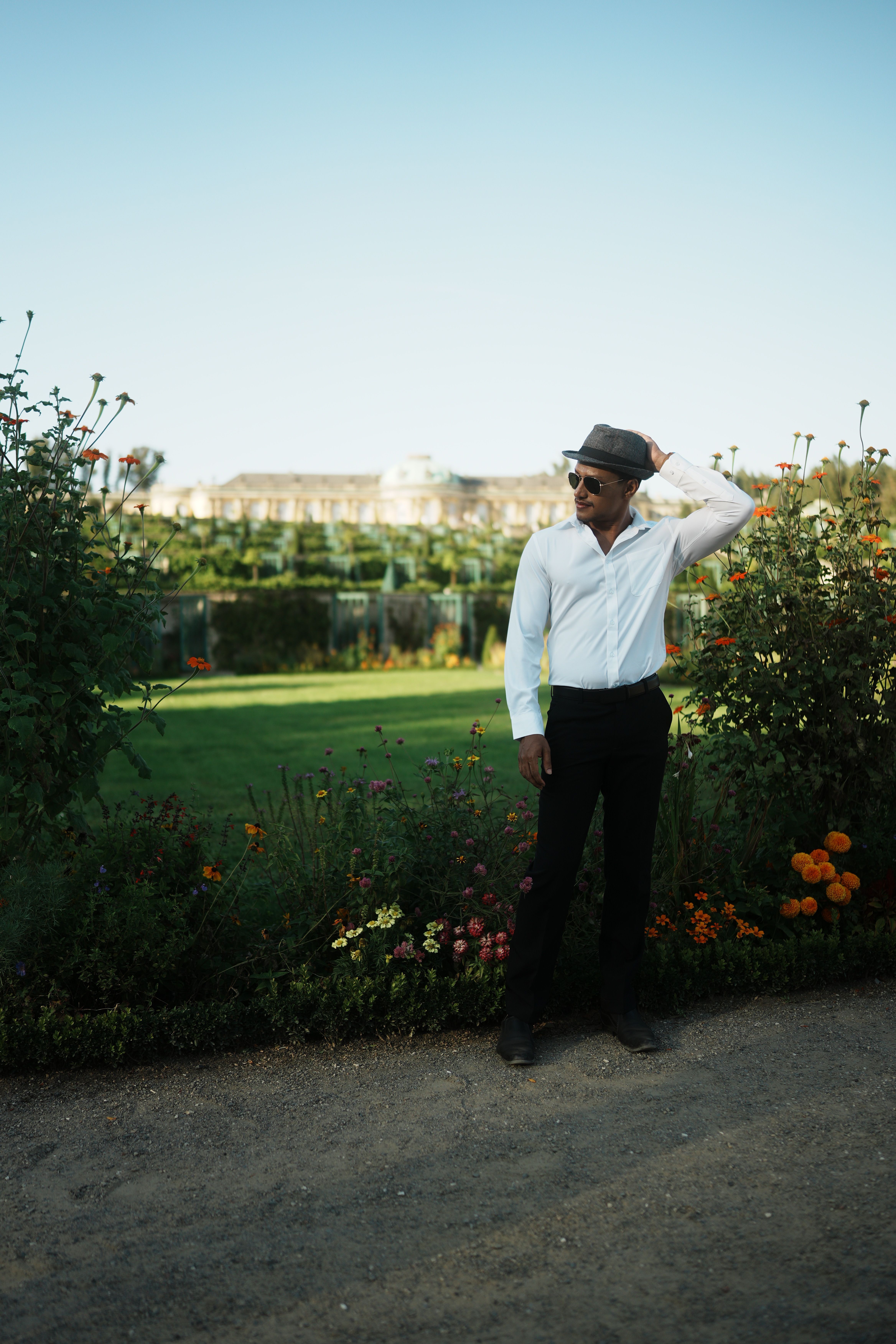 Stylish Man Posing in Sunny Garden Park · Free Stock Photo
