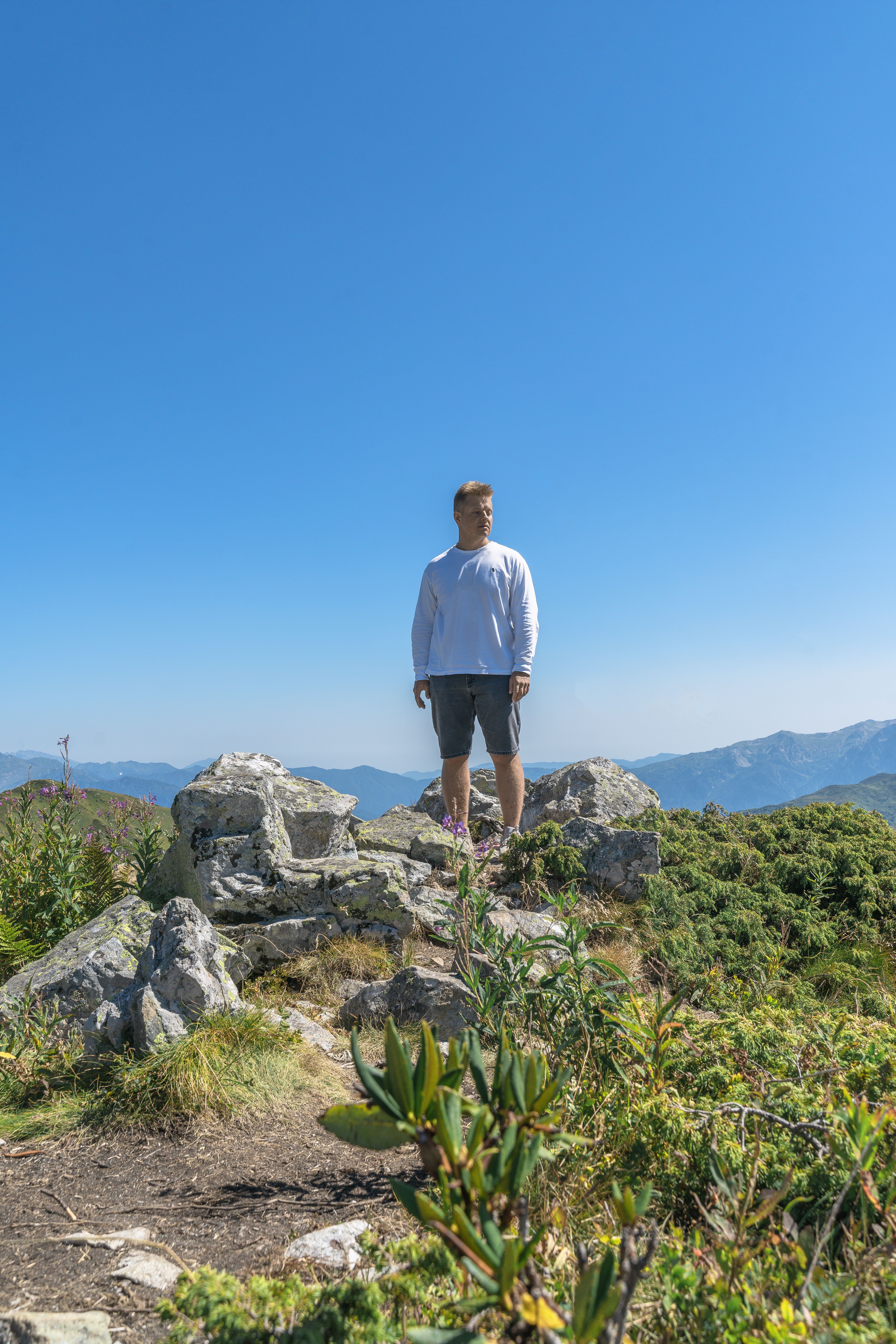 Man Standing on Hill with Scenic Mountain Views · Free Stock Photo