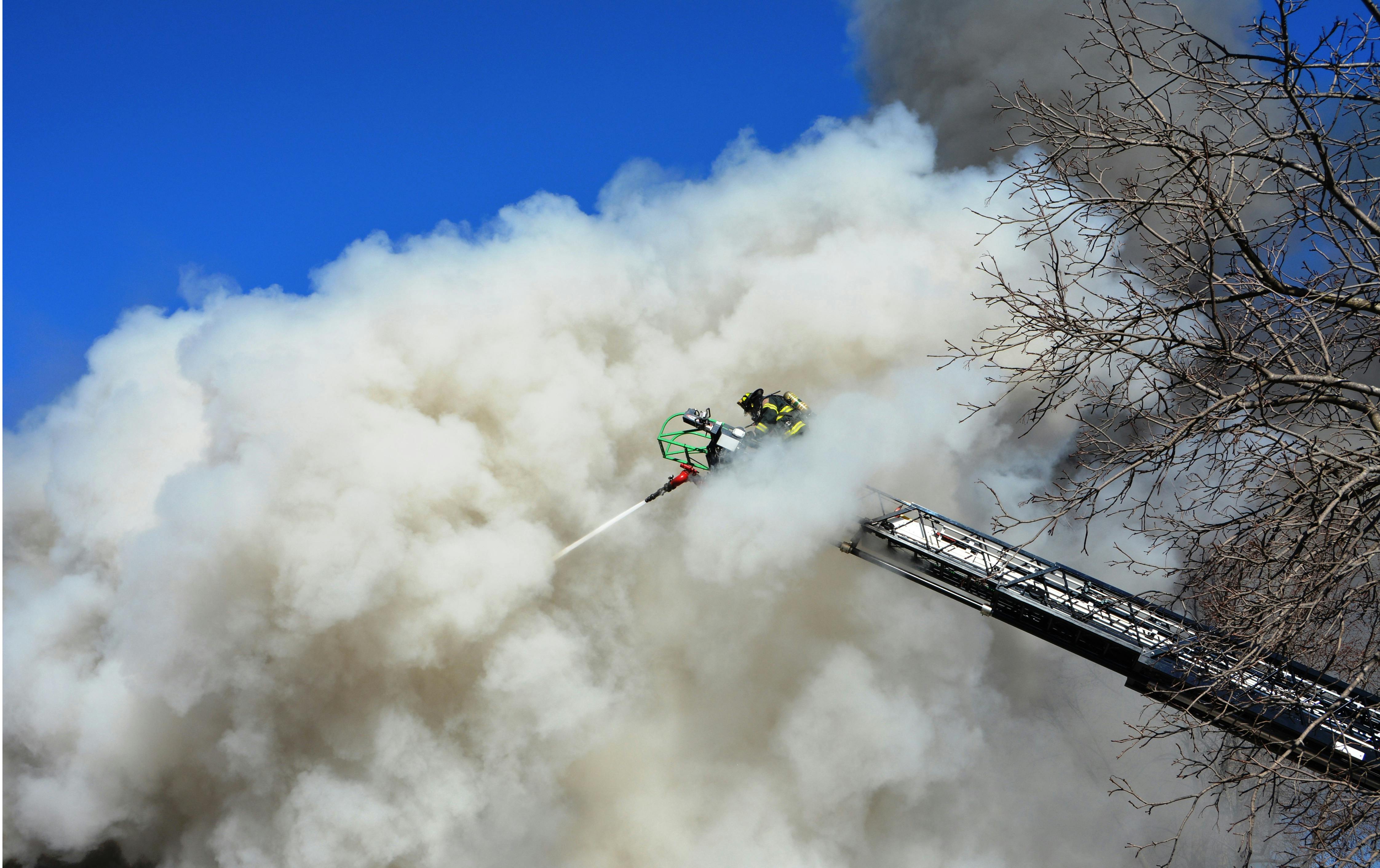 Firefighters Battling Large Smoke Cloud from Ladder · Free Stock Photo
