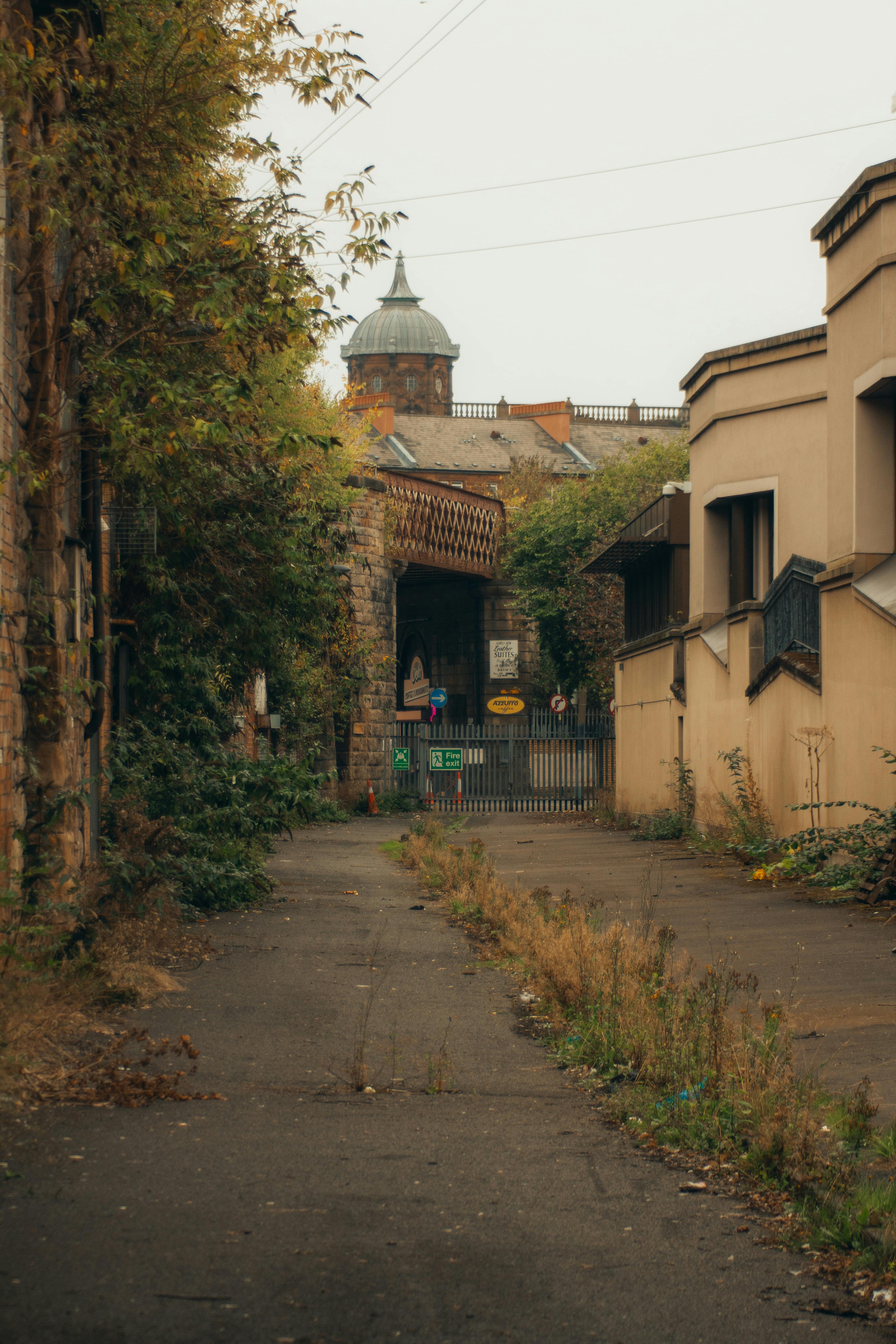 Narrow alley with archway and distant tower view · Free Stock Photo