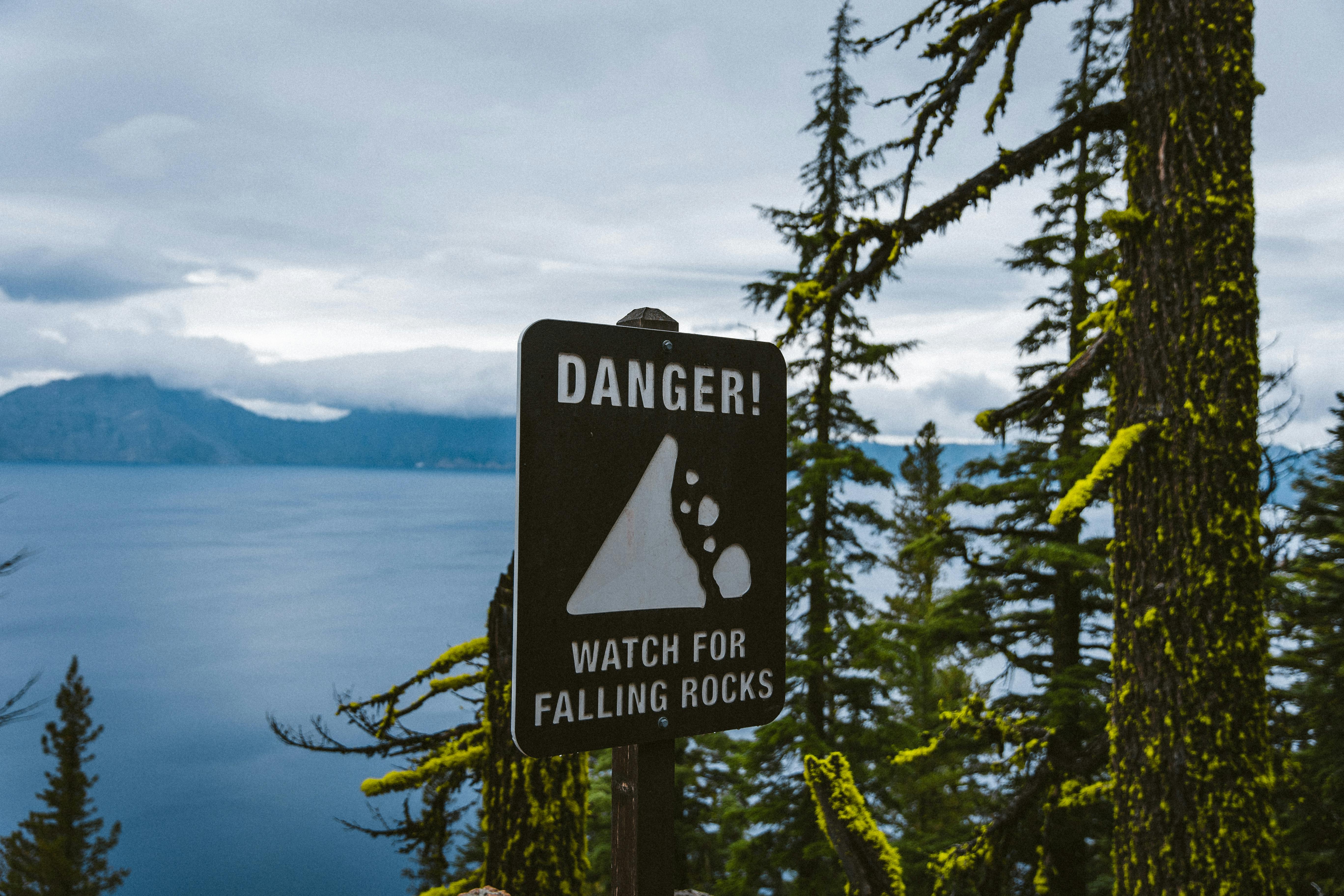 Watch for Falling Rocks Sign Near Lake · Free Stock Photo