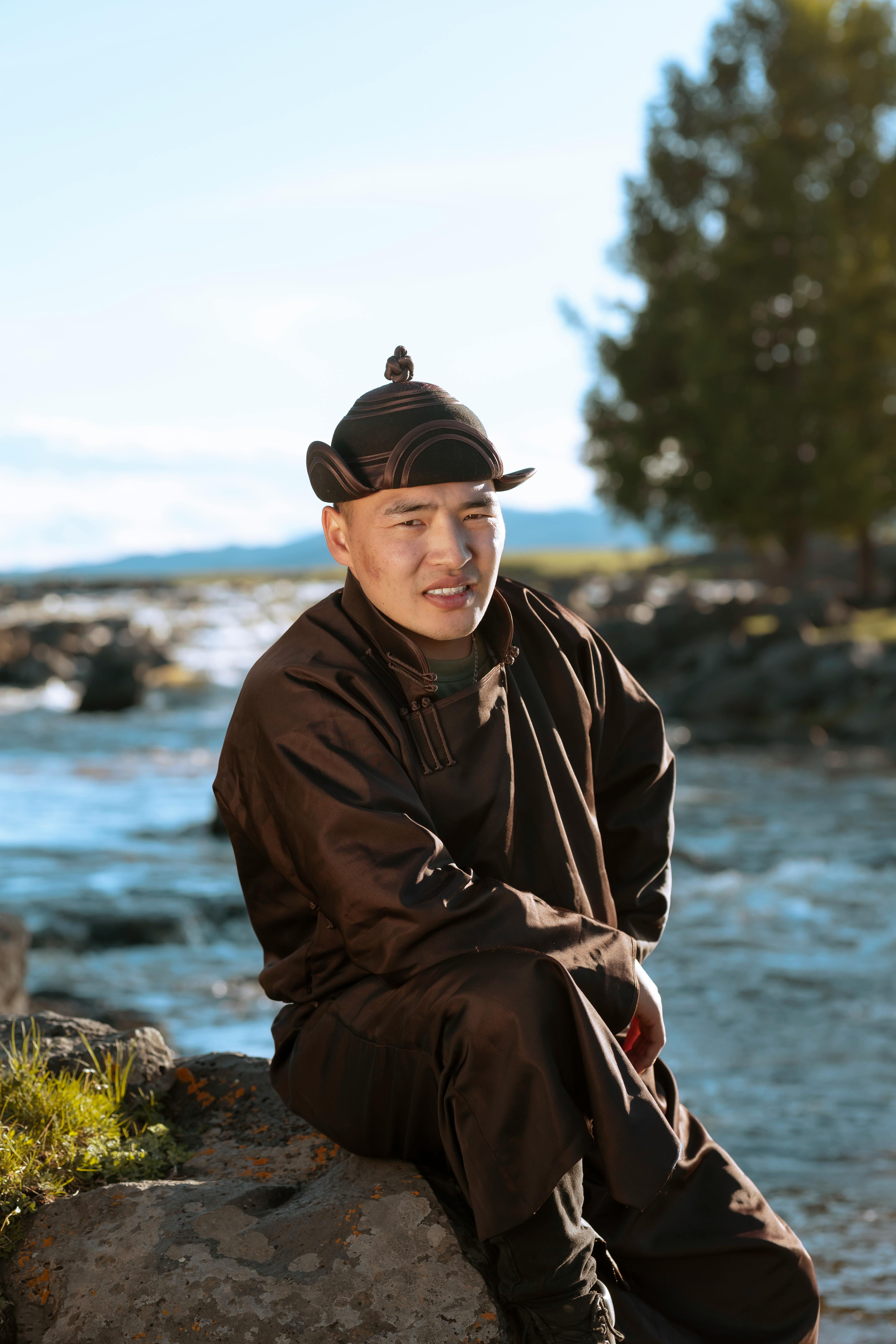 Man in Traditional Attire by Riverbank · Free Stock Photo