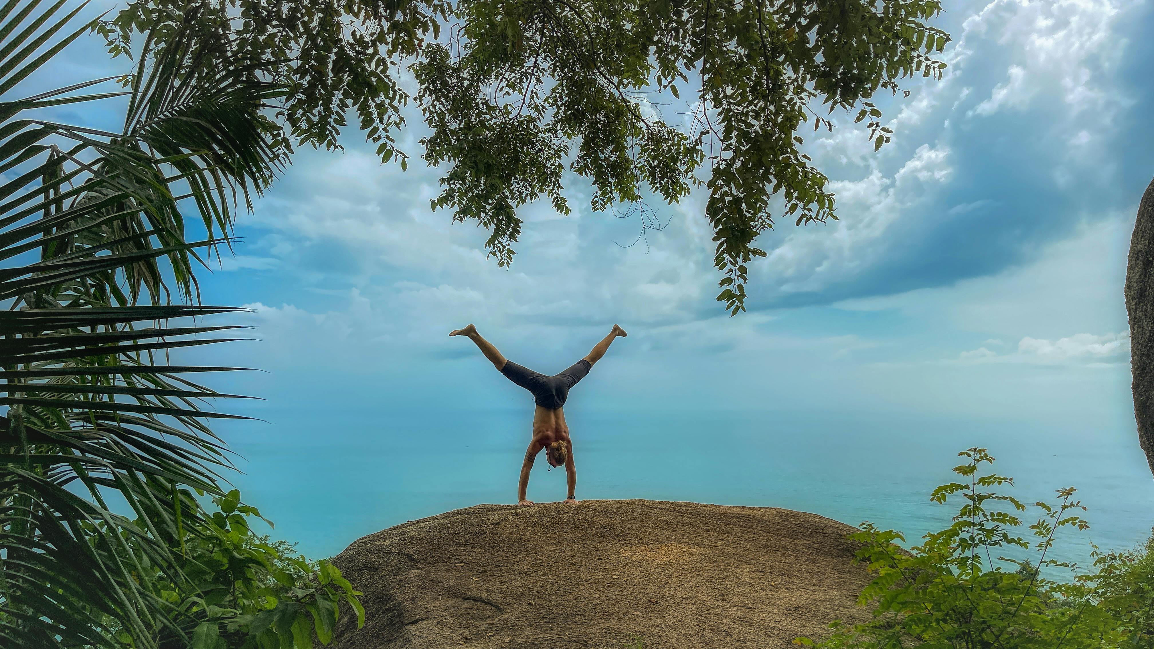 Man Performing Handstand on Seaside Rock · Free Stock Photo