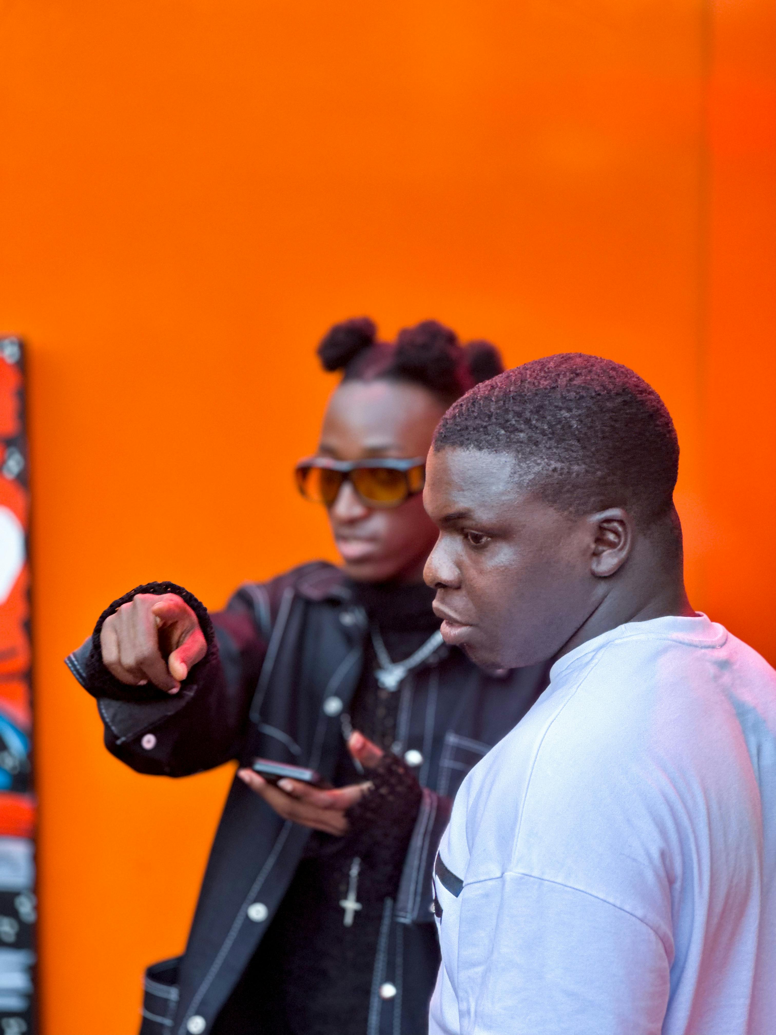 Stylish Urban Street Interaction with Vibrant Orange Backdrop · Free ...