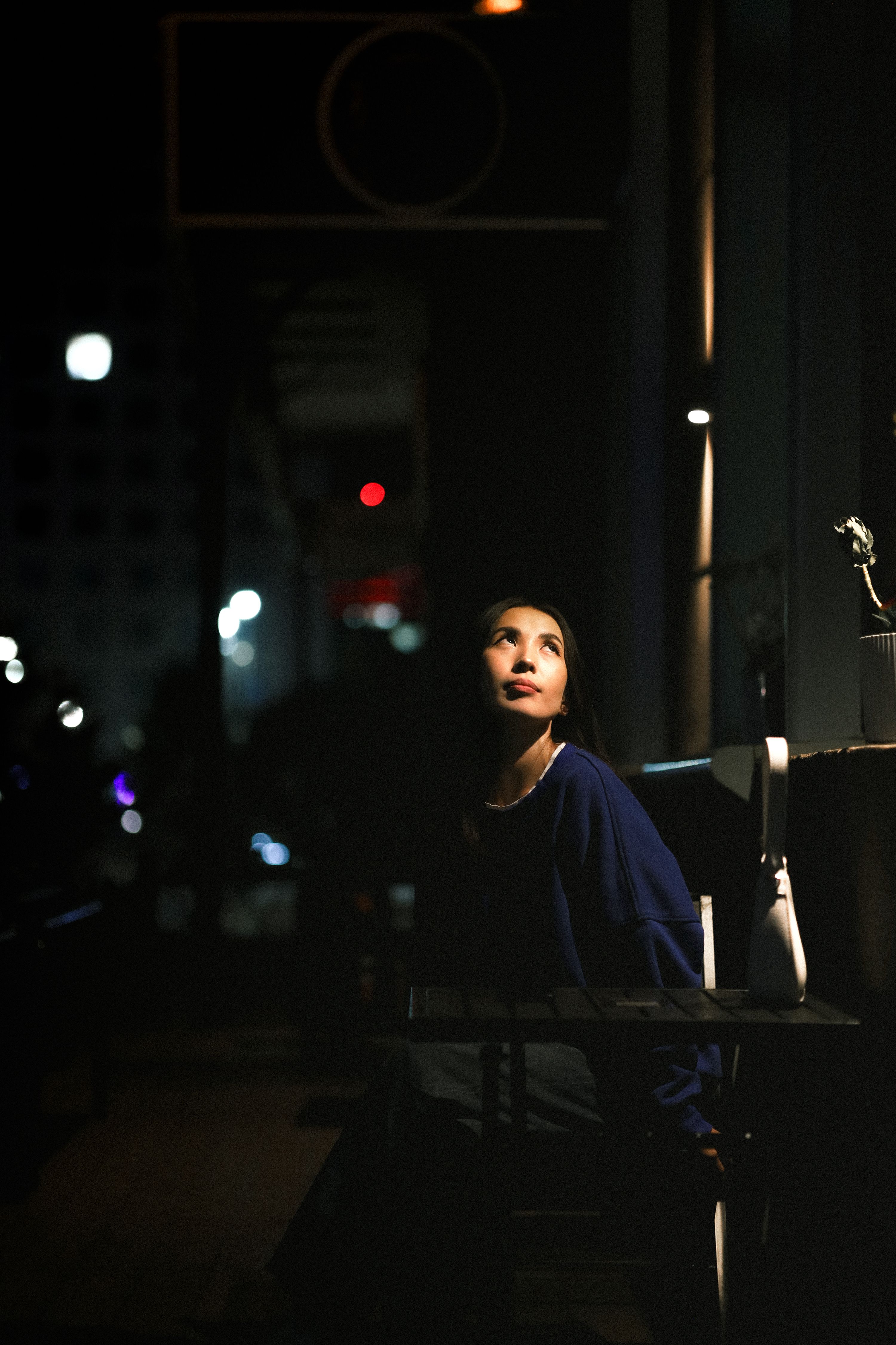 Woman Gazing Upwards in Nighttime Urban Scene · Free Stock Photo