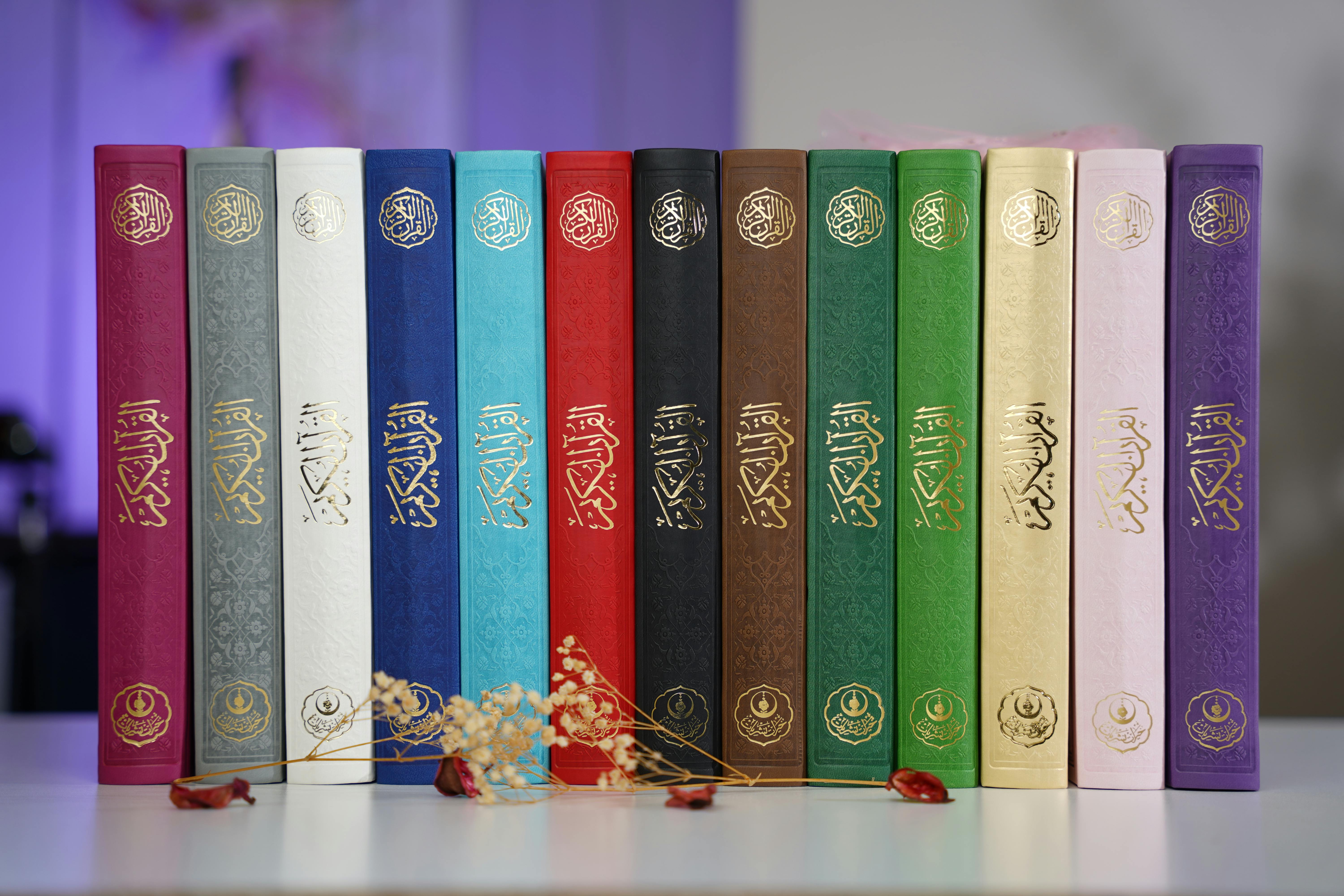 Colorful Quran Hardcover Collection on Display · Free Stock Photo