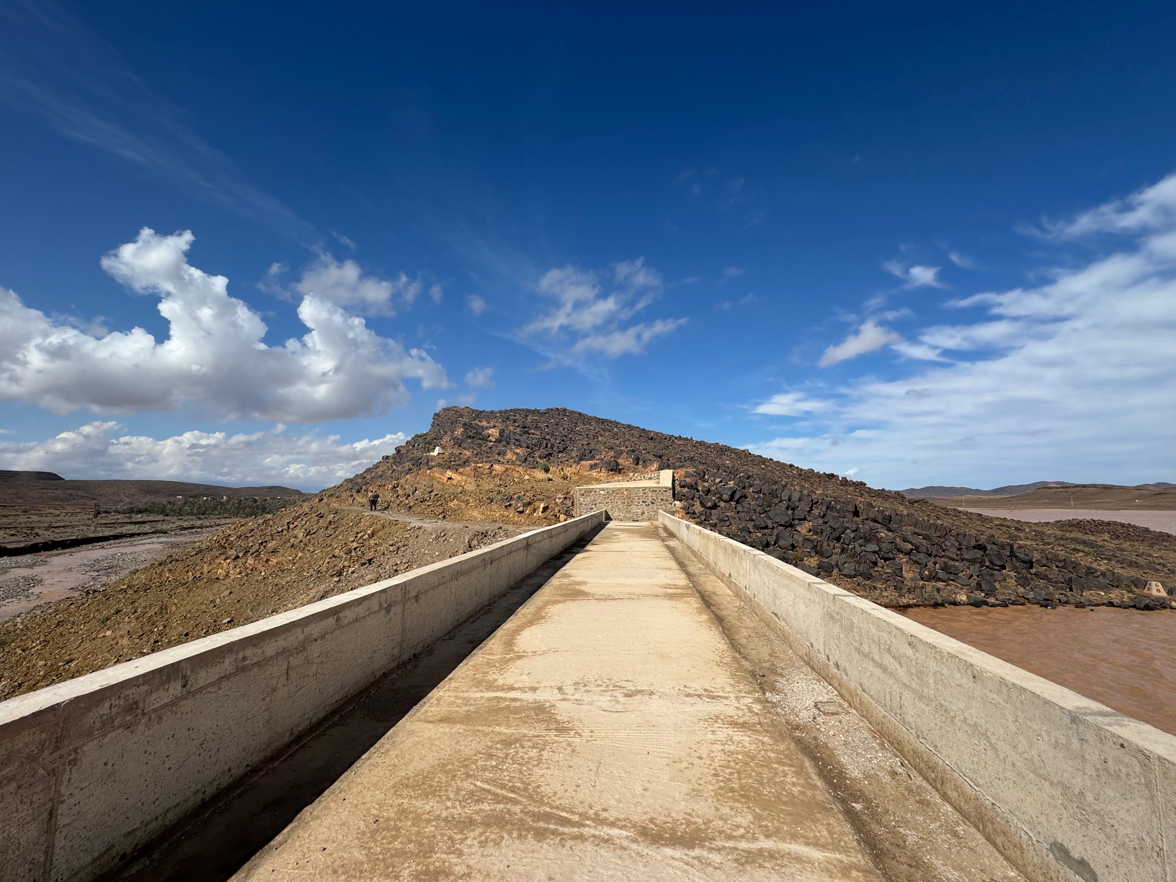 Concrete Walkway Leading to Rocky Hill under Blue Sky · Free Stock Photo