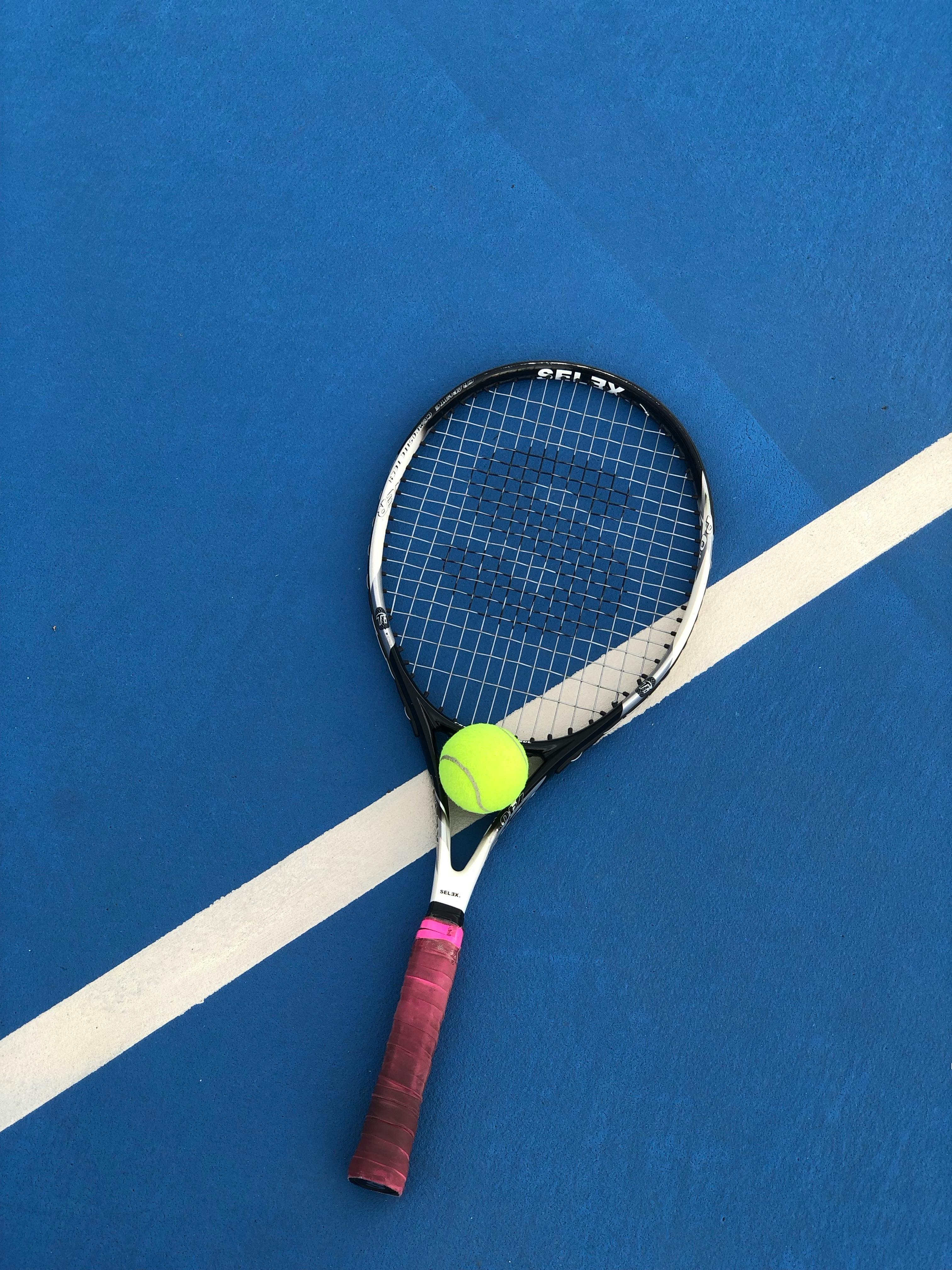 Tennis Racket and Ball on Blue Court Surface · Free Stock Photo