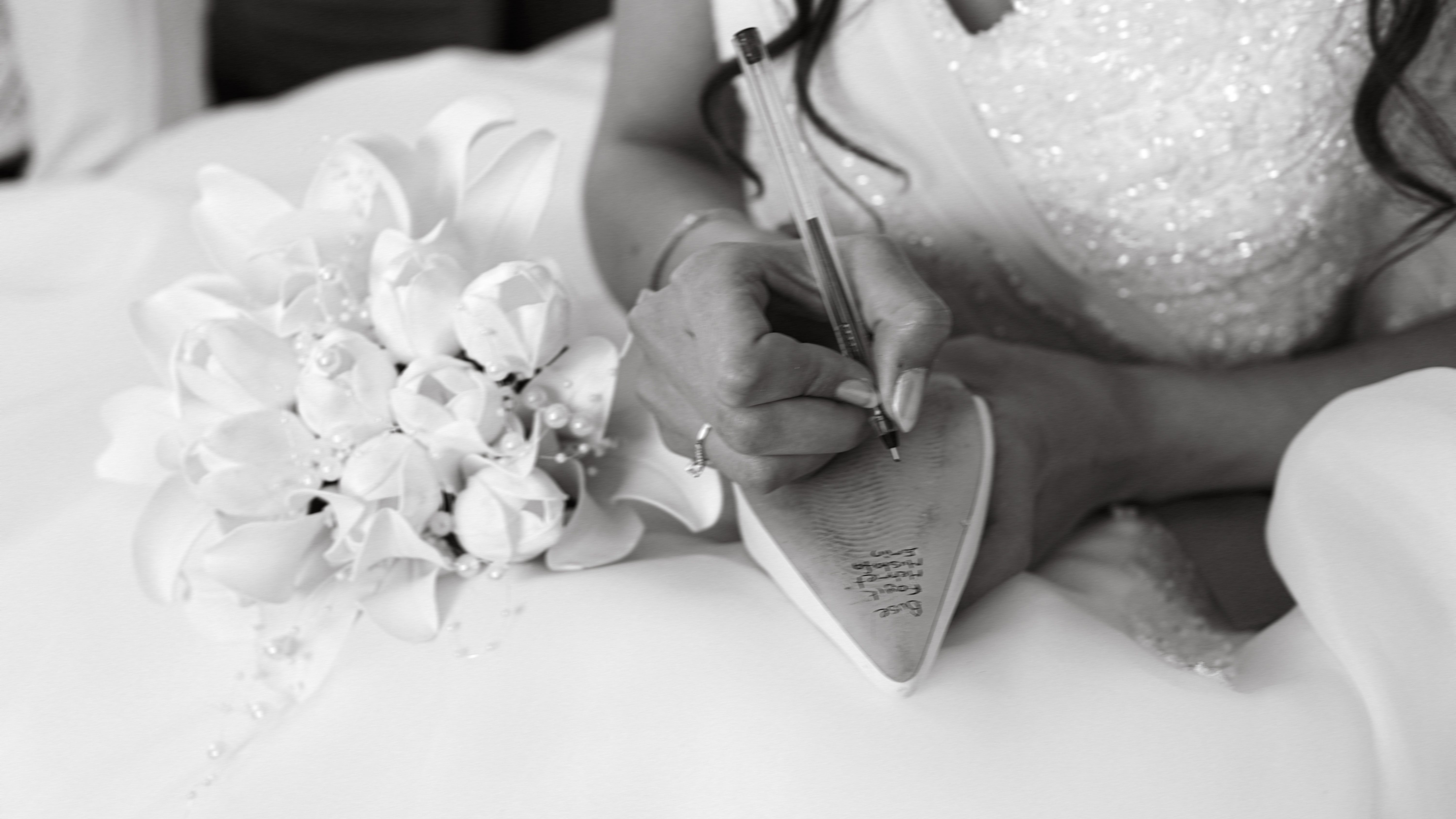 Bride writing names inside high heel shoe · Free Stock Photo