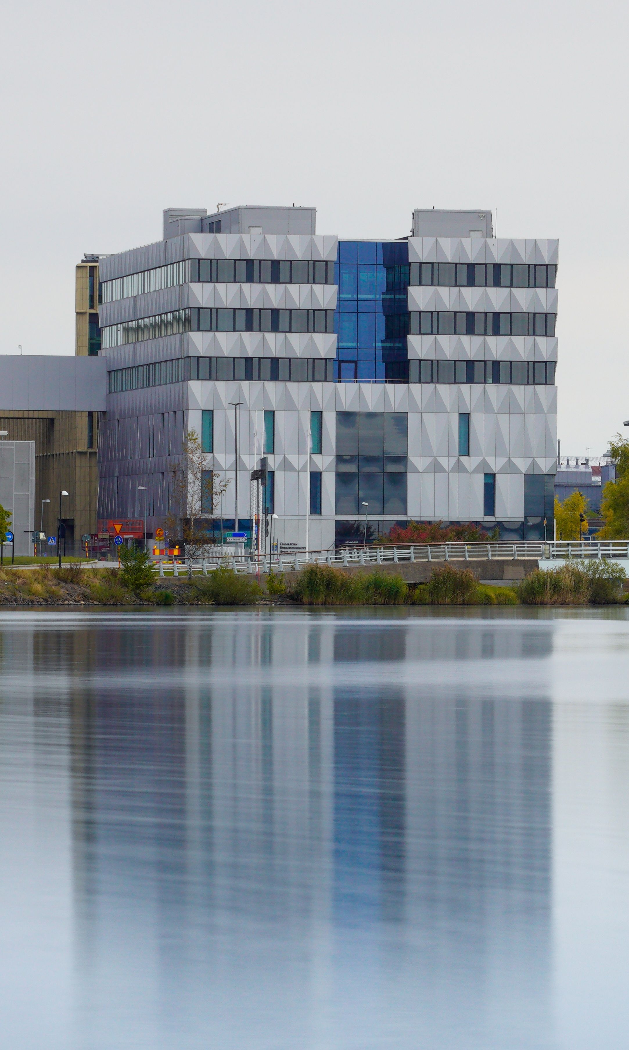 Modern Building Reflecting in Tranquil Water · Free Stock Photo