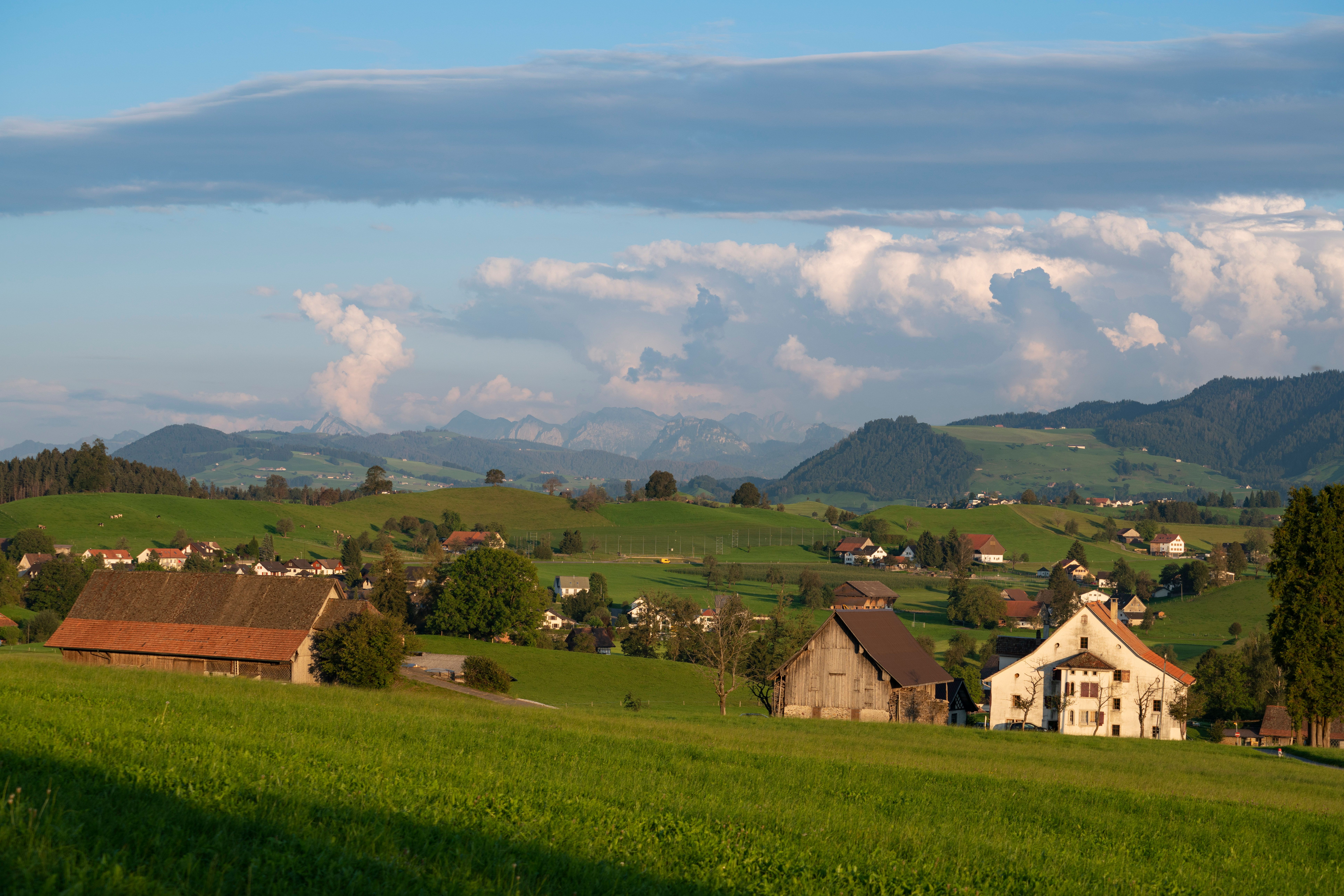 Scenic Swiss Countryside Landscape with Farmhouses · Free Stock Photo