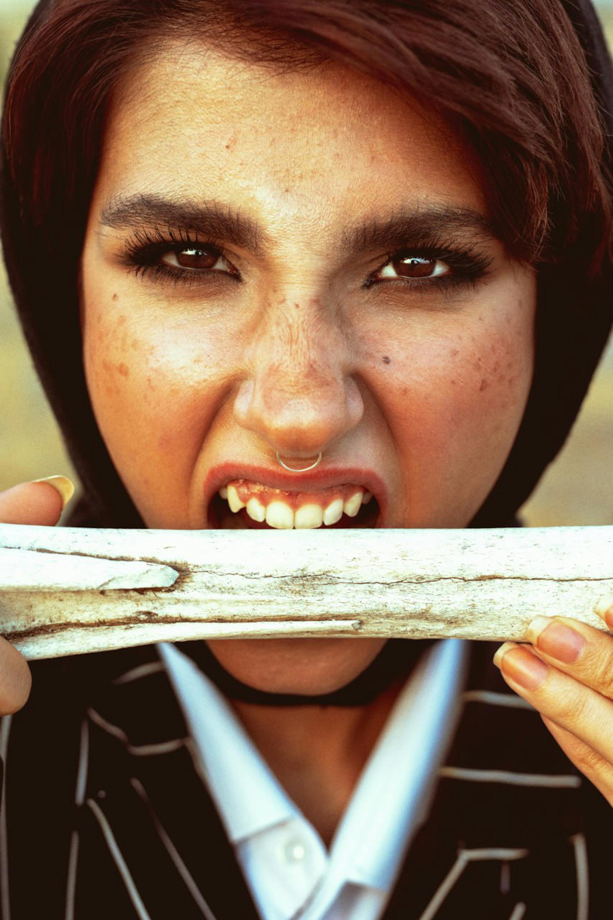 Woman Biting a Wooden Stick Face Close-Up · Free Stock Photo