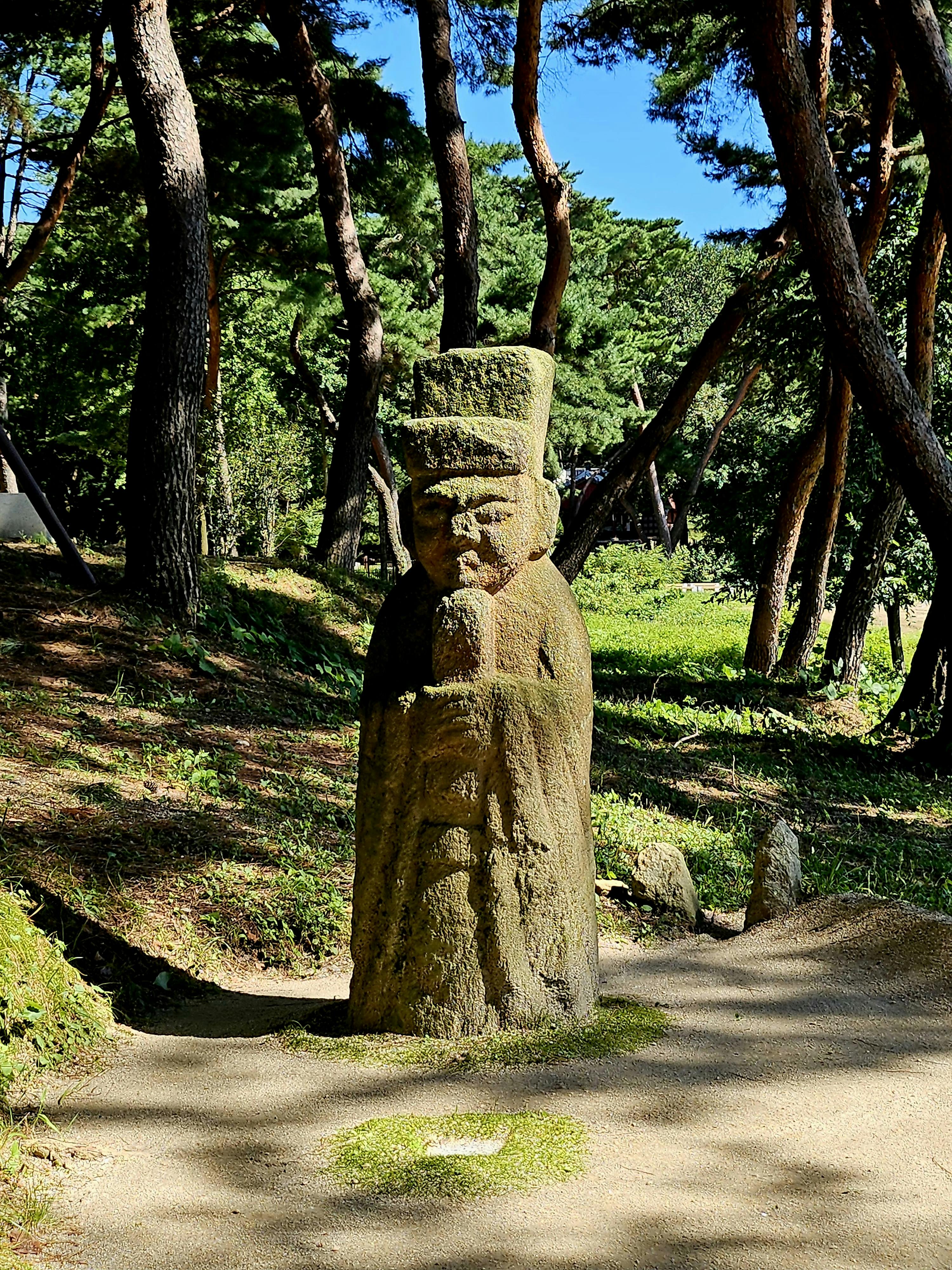 Ancient Stone Statue in Lush Forest Setting · Free Stock Photo