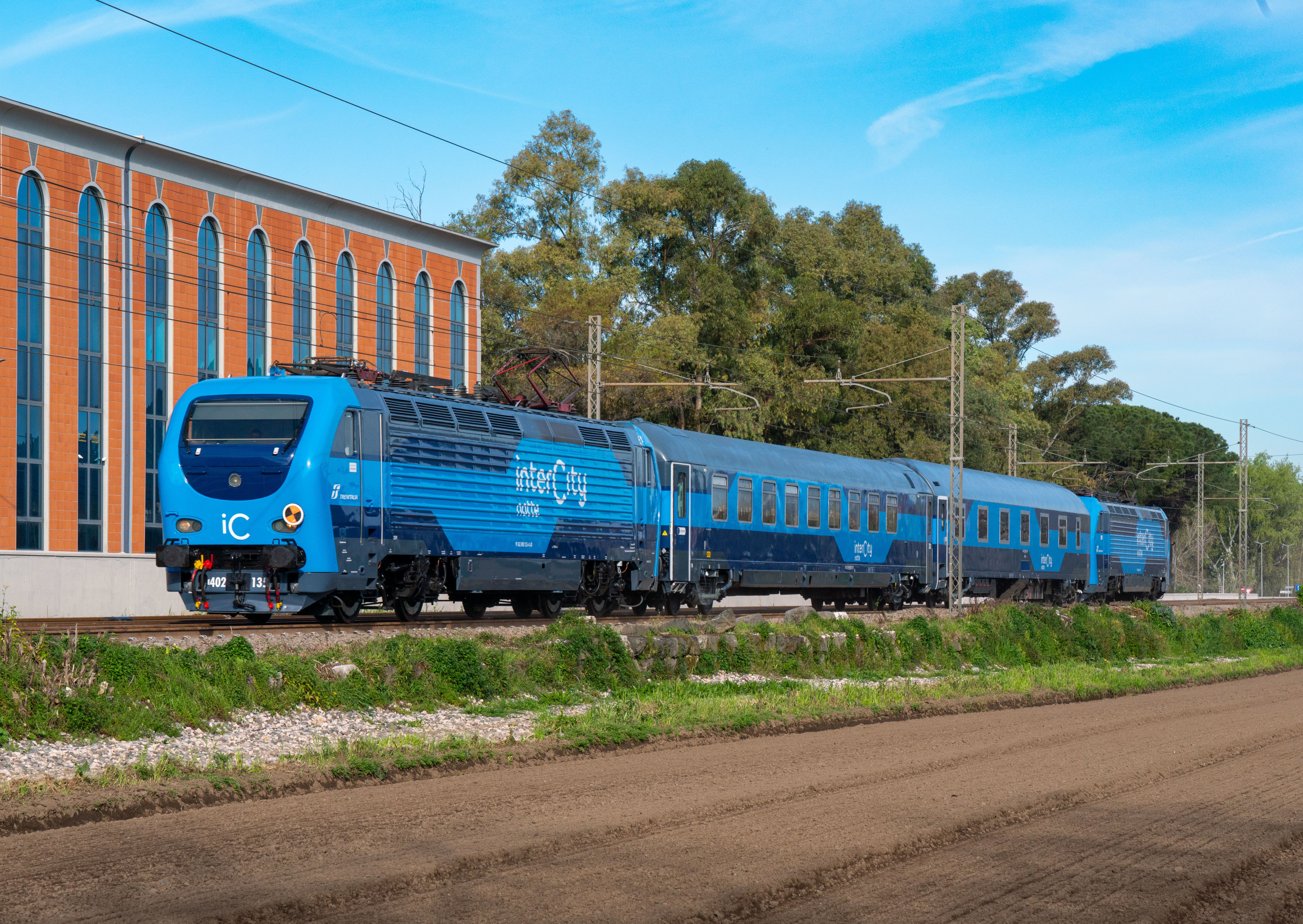 Modern Blue Train Passing by Historic Caserta Building · Free Stock Photo