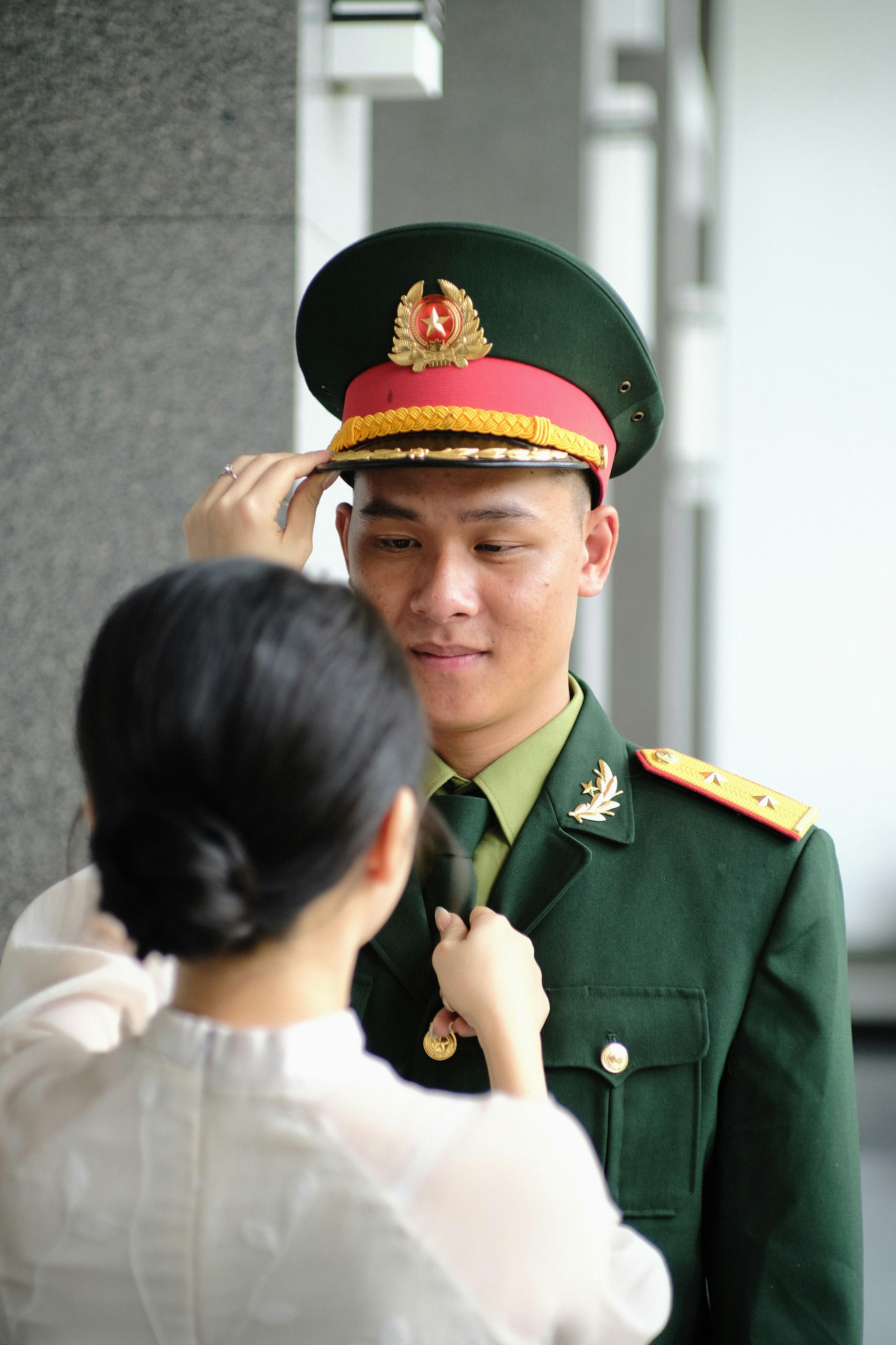 Military Officer Getting Uniform Adjusted Indoors · Free Stock Photo
