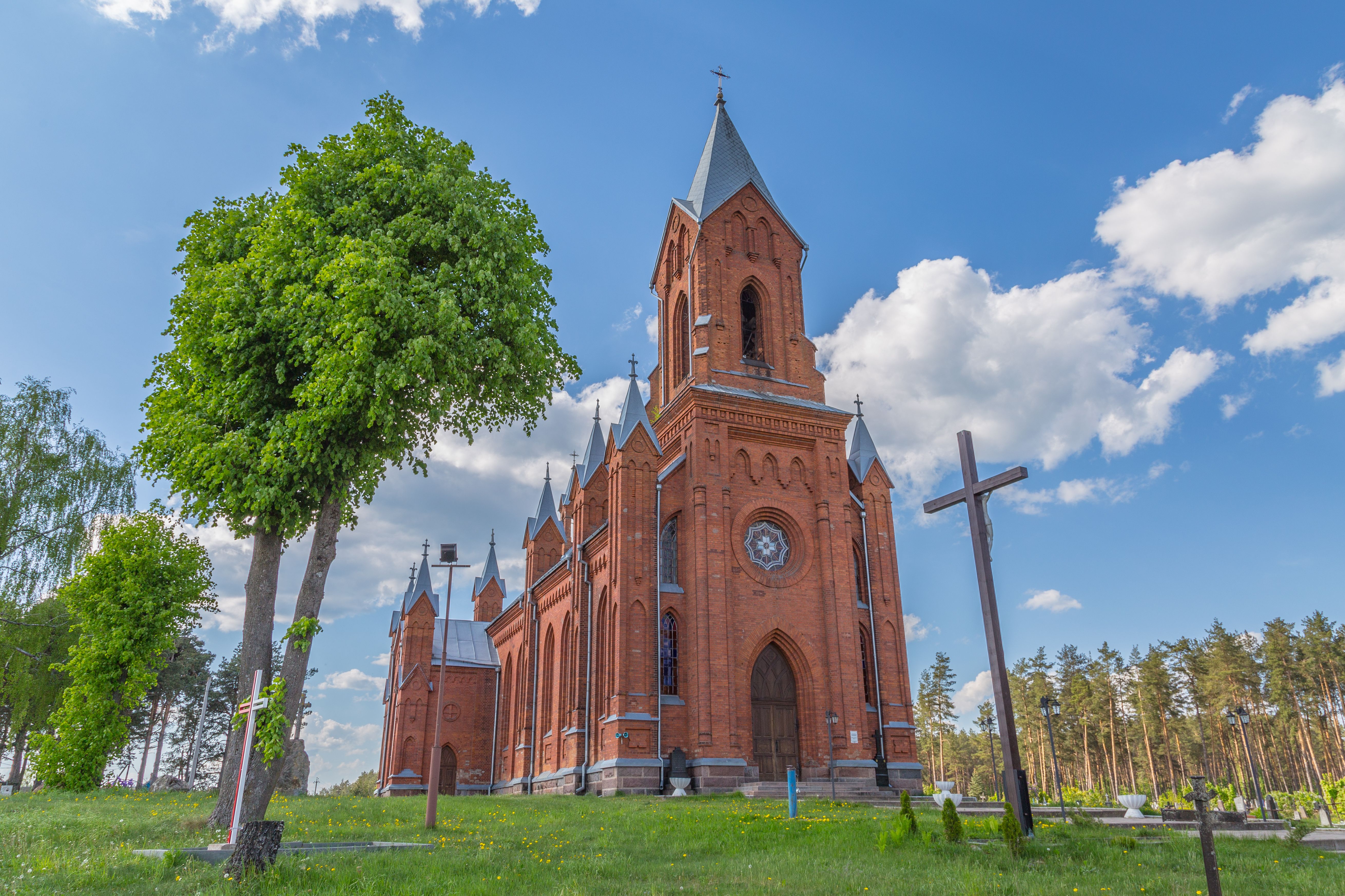 Majestic Red Brick Gothic Church in Lush Landscape · Free Stock Photo