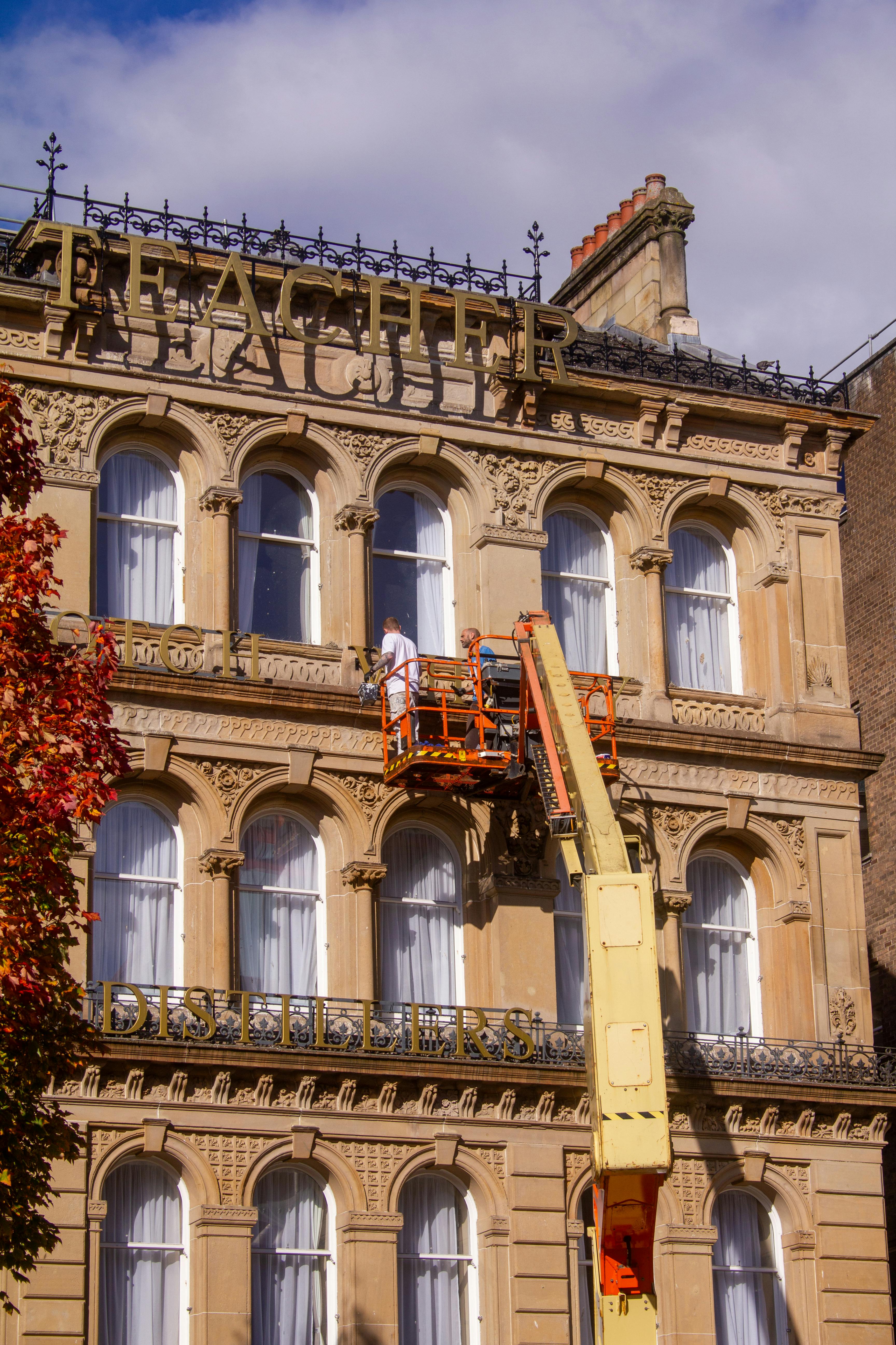 High-rise building maintenance on sunny day · Free Stock Photo