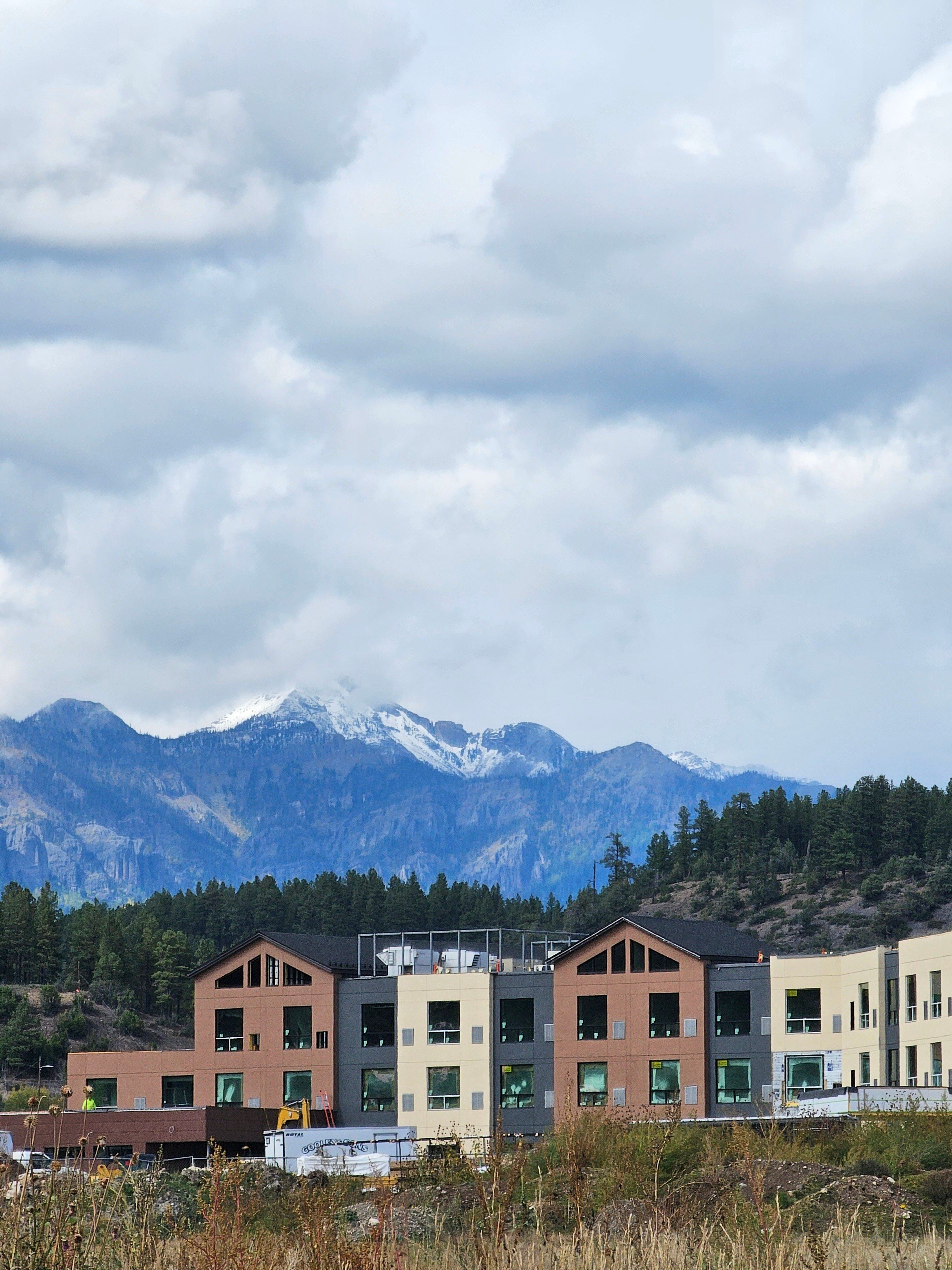 Modern Buildings Against Snowy Mountain Range · Free Stock Photo