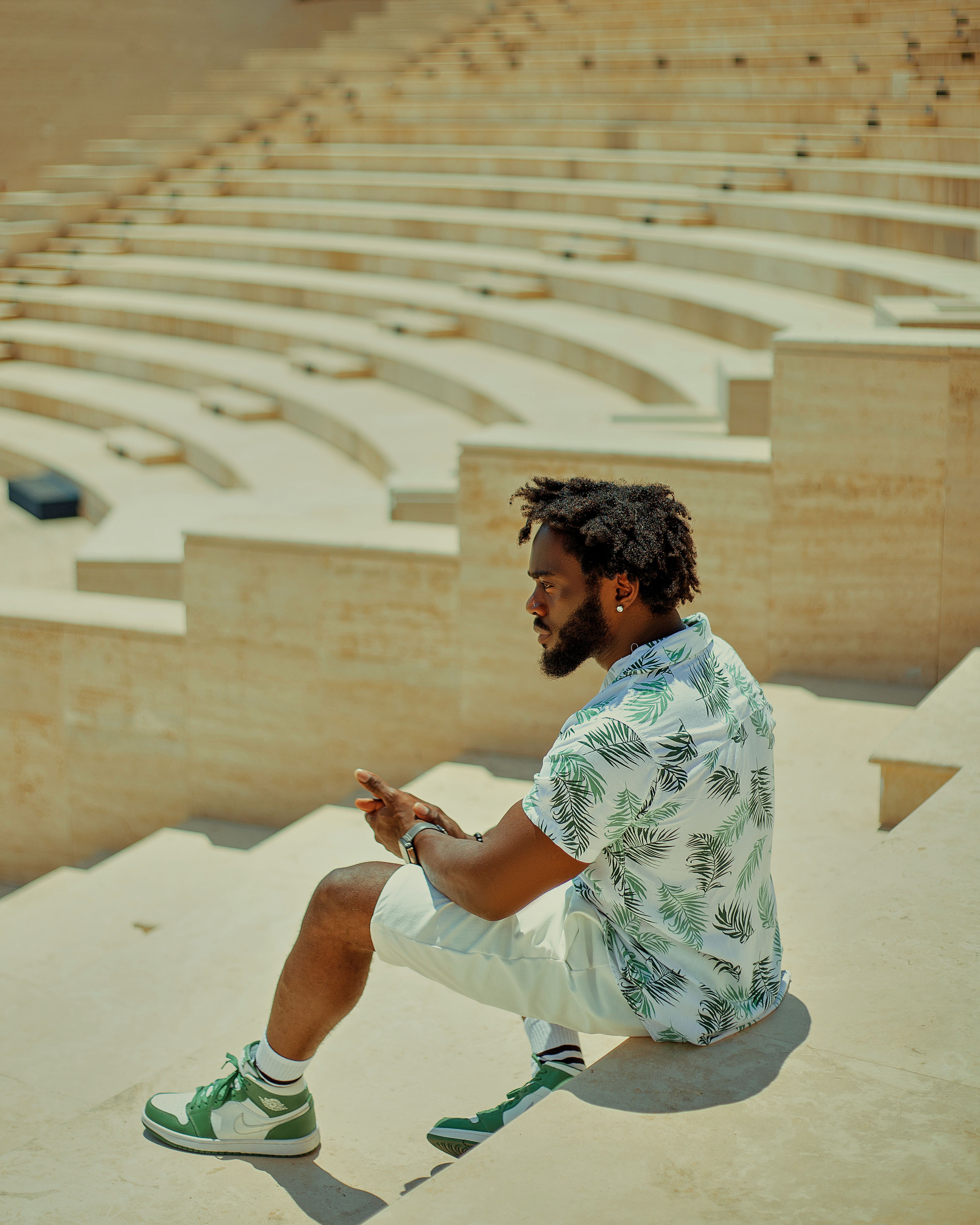 Man Sitting on Steps of Ancient Amphitheater · Free Stock Photo