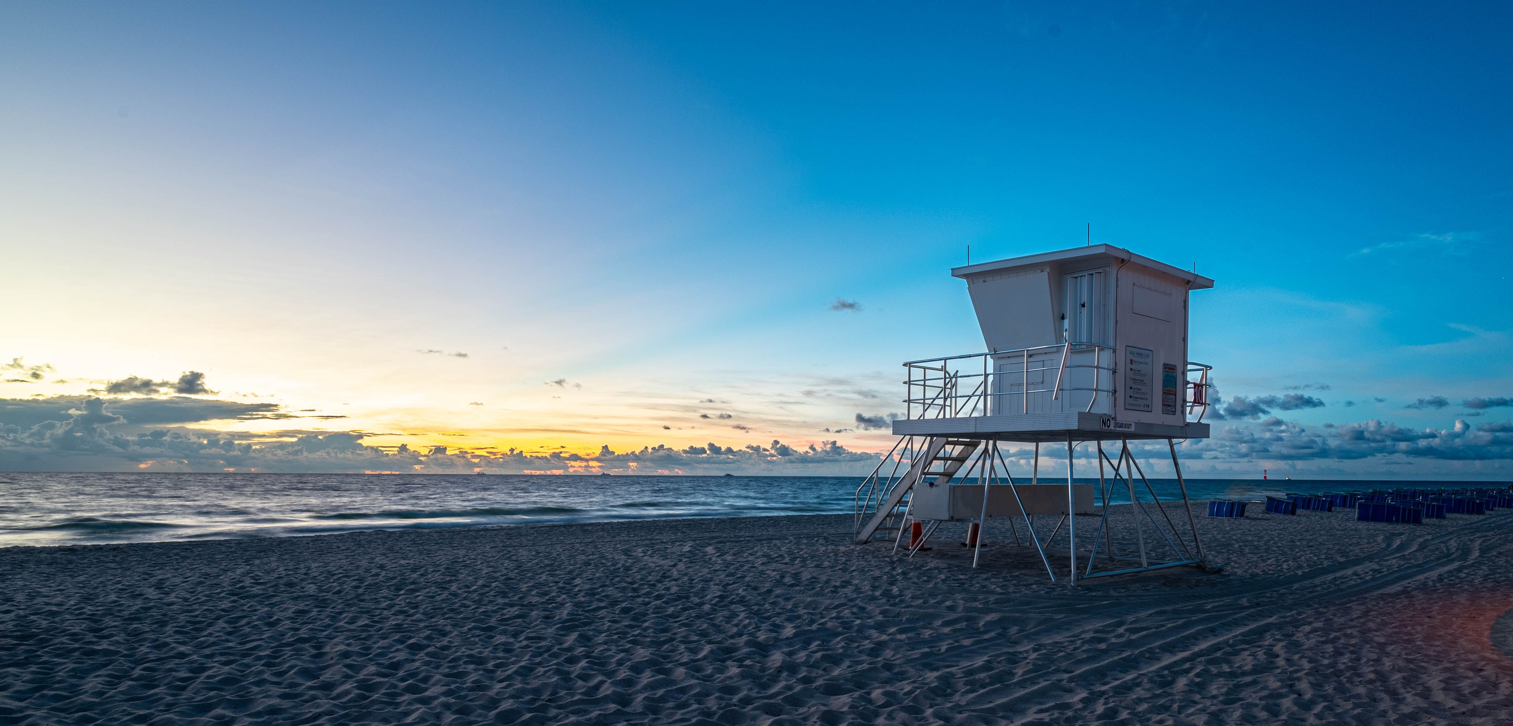 Lifeguard building on seashore against sundown sky · Free Stock Photo