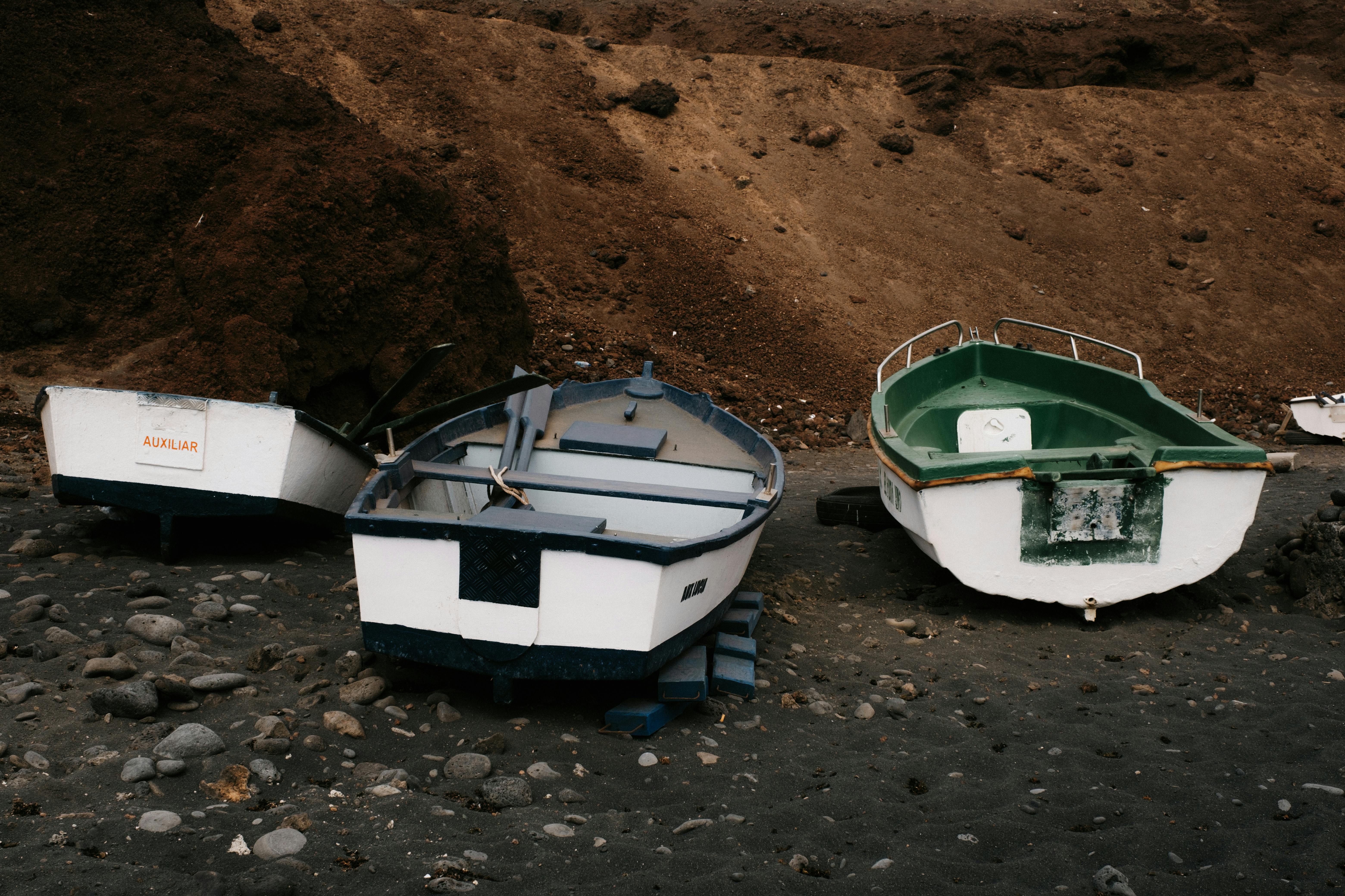 Beached Fishing Boats on Rocky Shoreline · Free Stock Photo