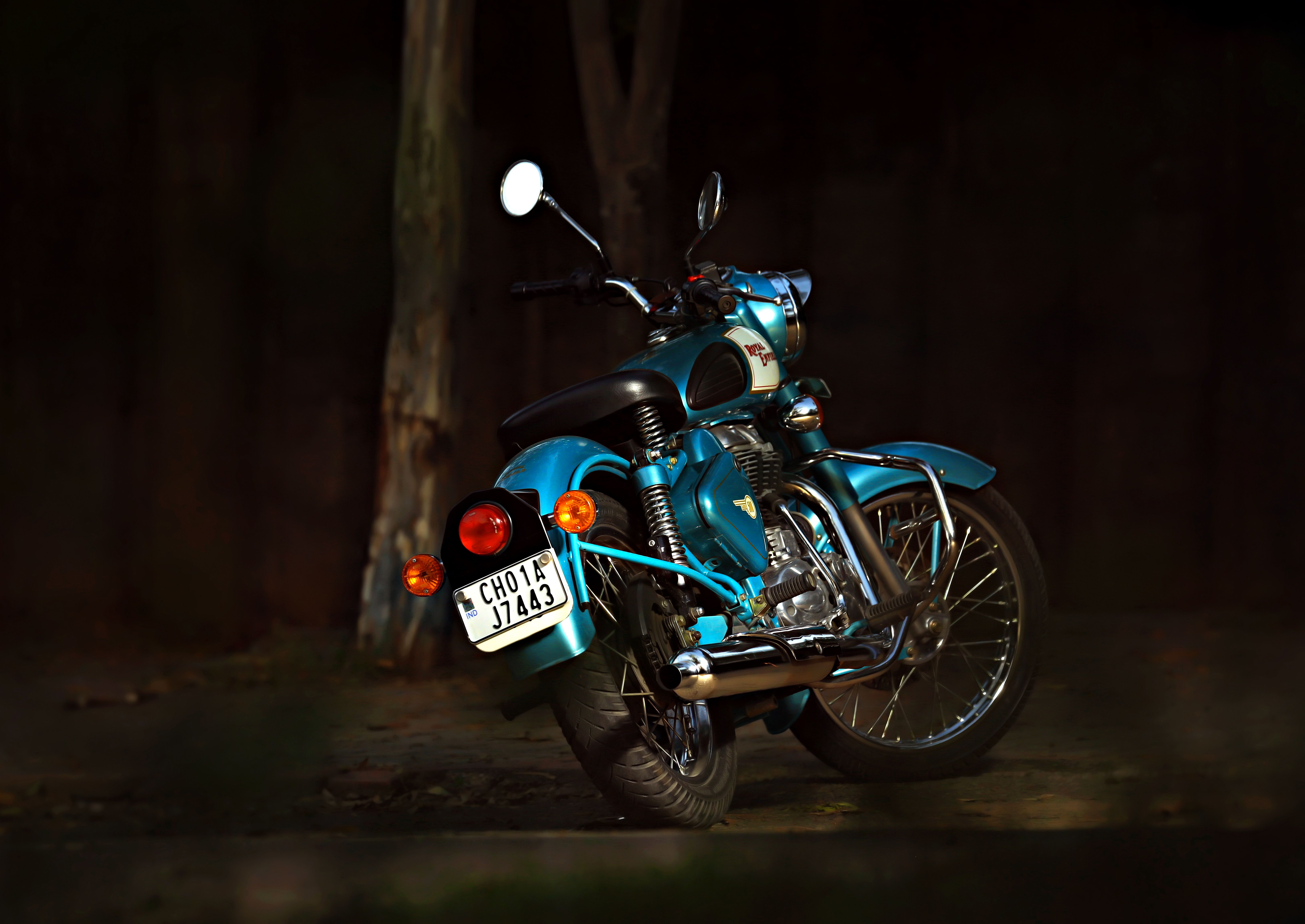 Vintage Blue Motorcycle in Shadowy Forest Setting · Free Stock Photo