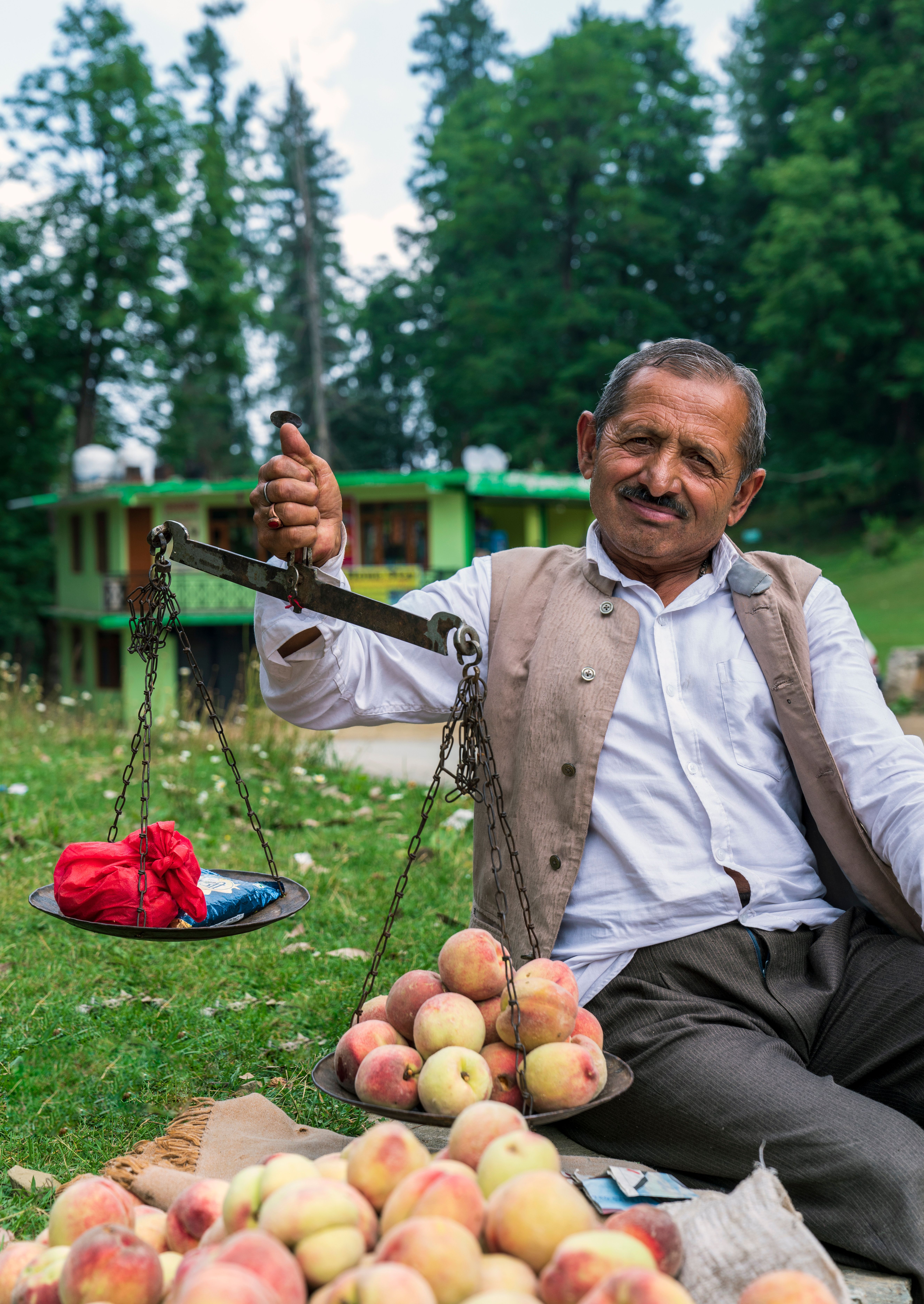 Local Farmer Weighing Fresh Produce Outdoors · Free Stock Photo
