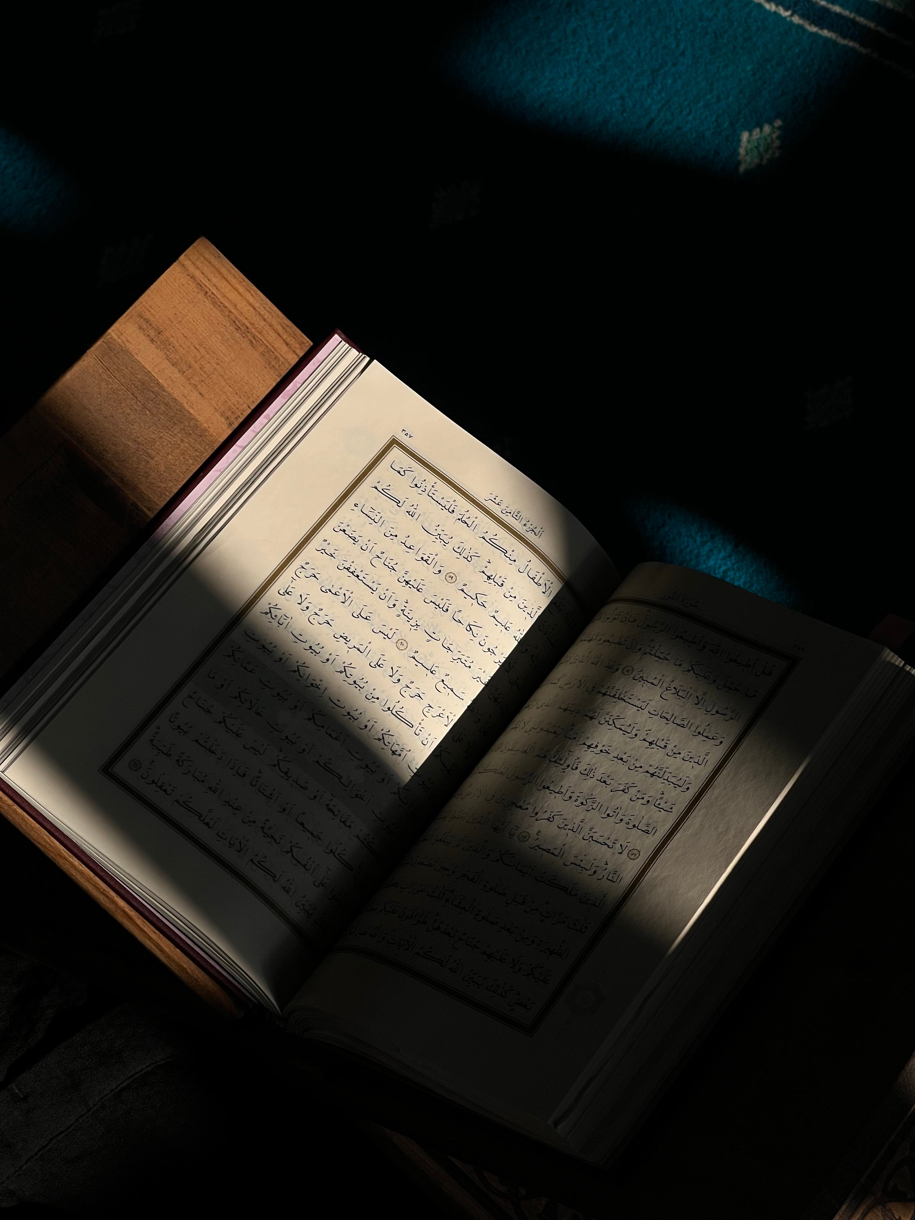 Open Quran with Sunlight Cast Across Pages · Free Stock Photo