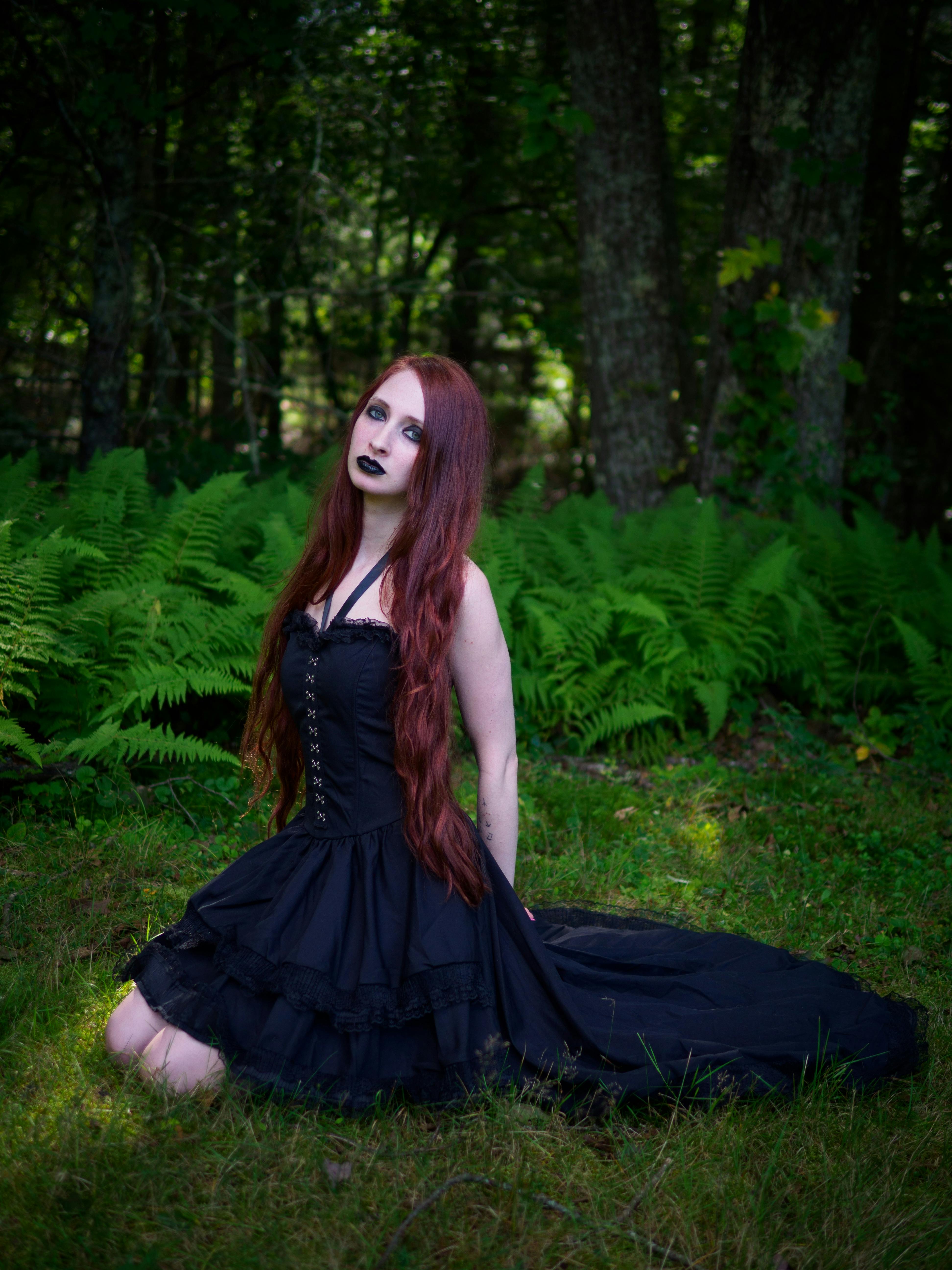 Gothic Woman in Black Dress Amidst Forest Ferns · Free Stock Photo