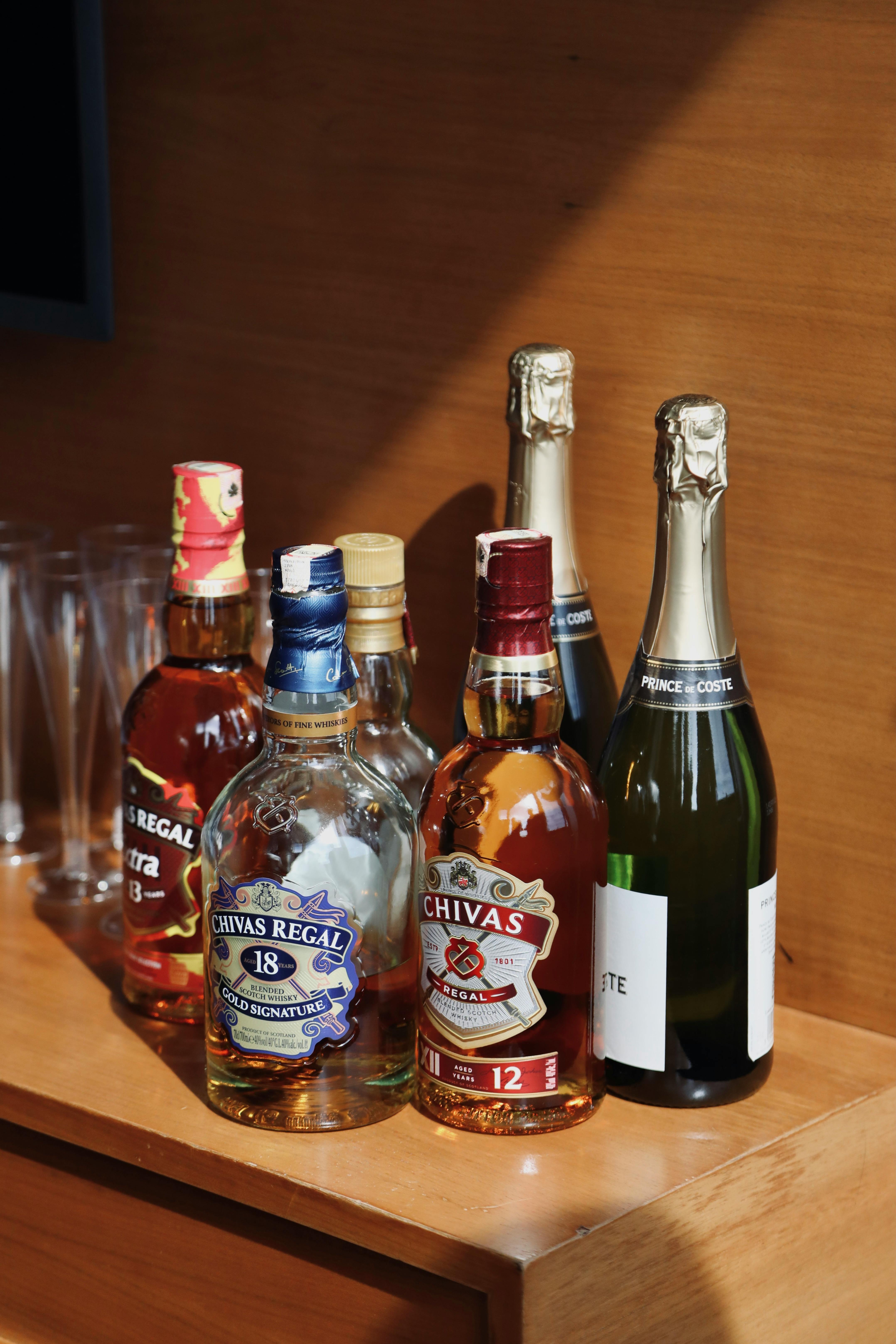 Assorted Liquor Bottles on Wooden Surface · Free Stock Photo