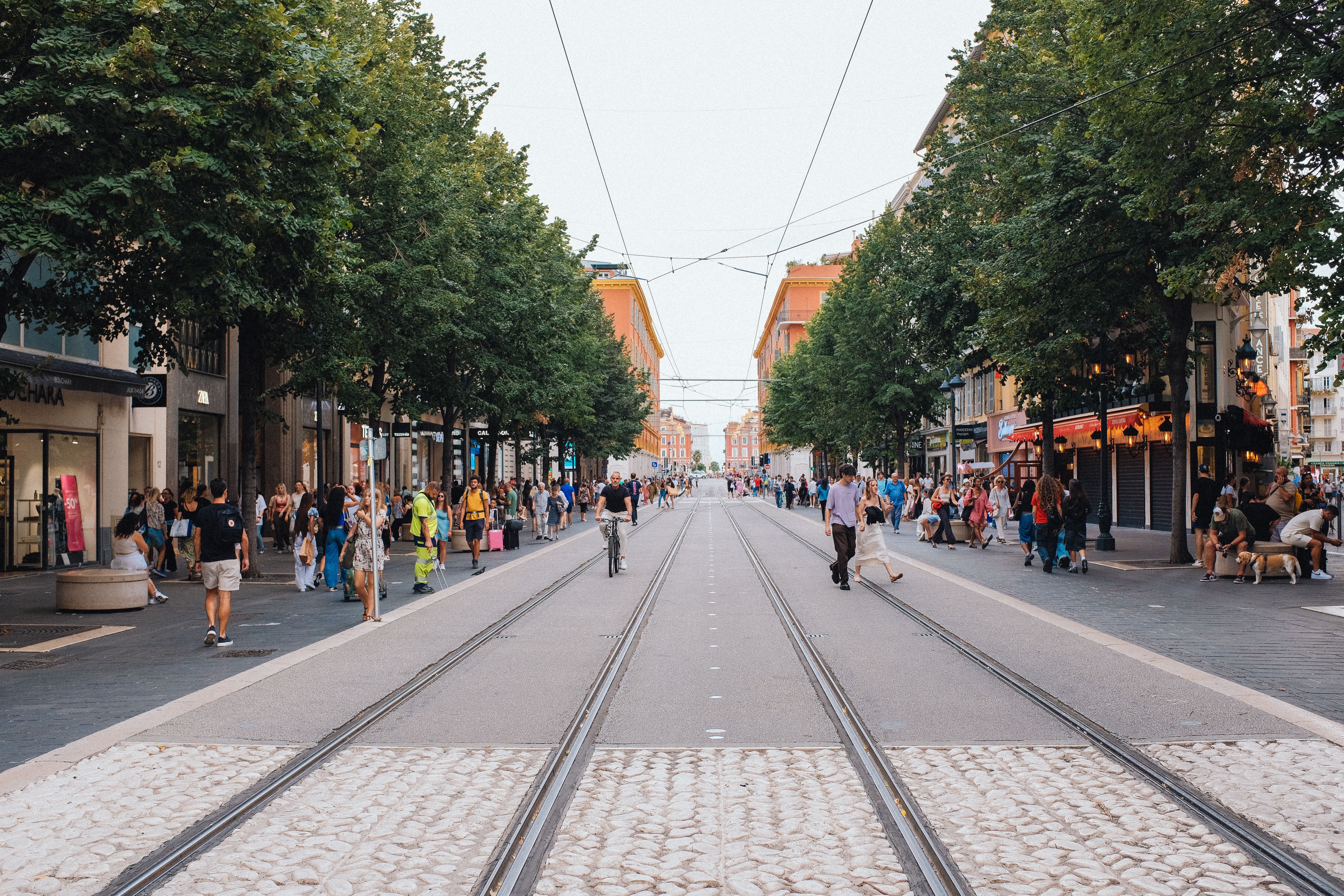 Vibrant City Street with Shops and Pedestrians · Free Stock Photo