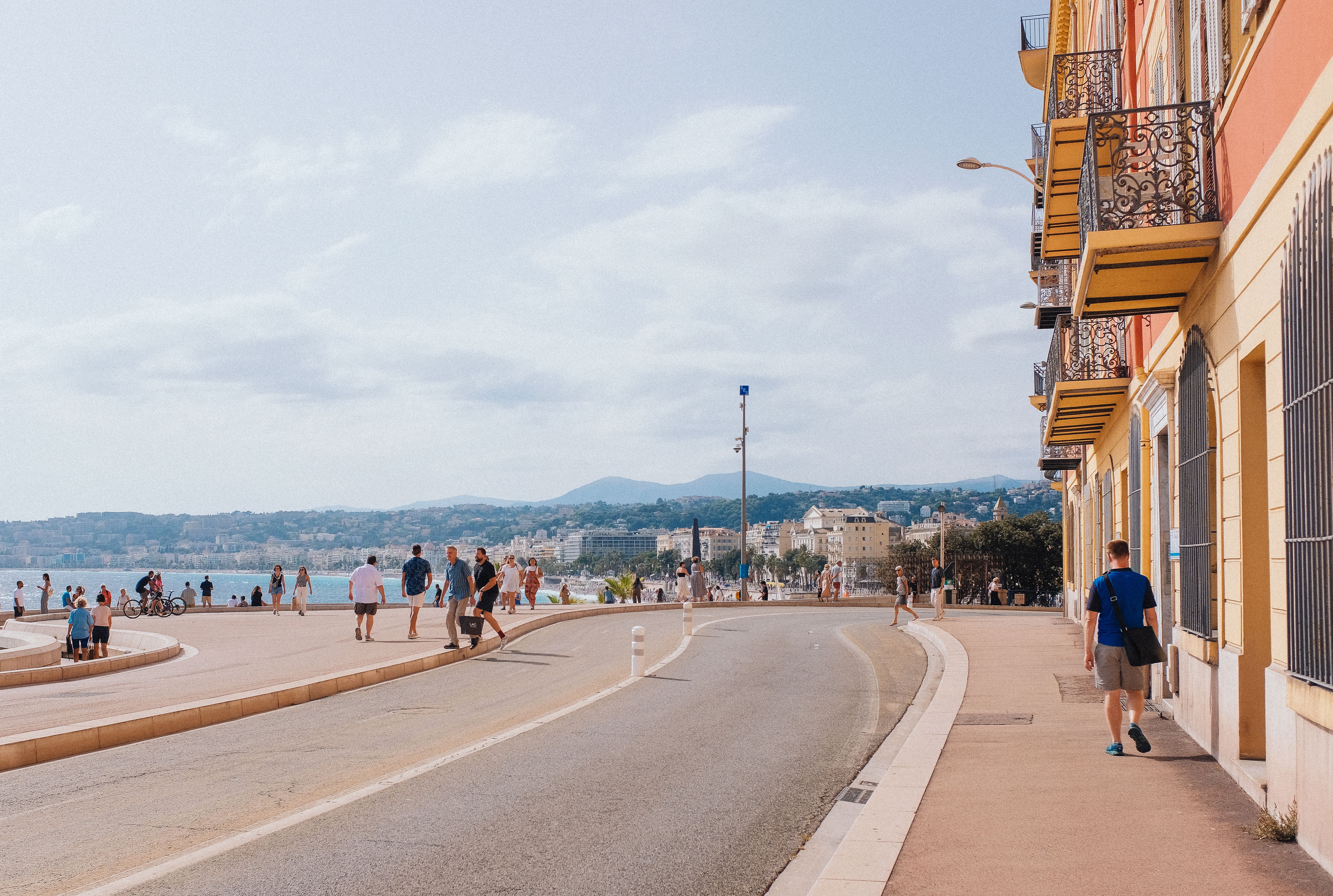 Sunny Coastal Promenade with Walking Tourists · Free Stock Photo