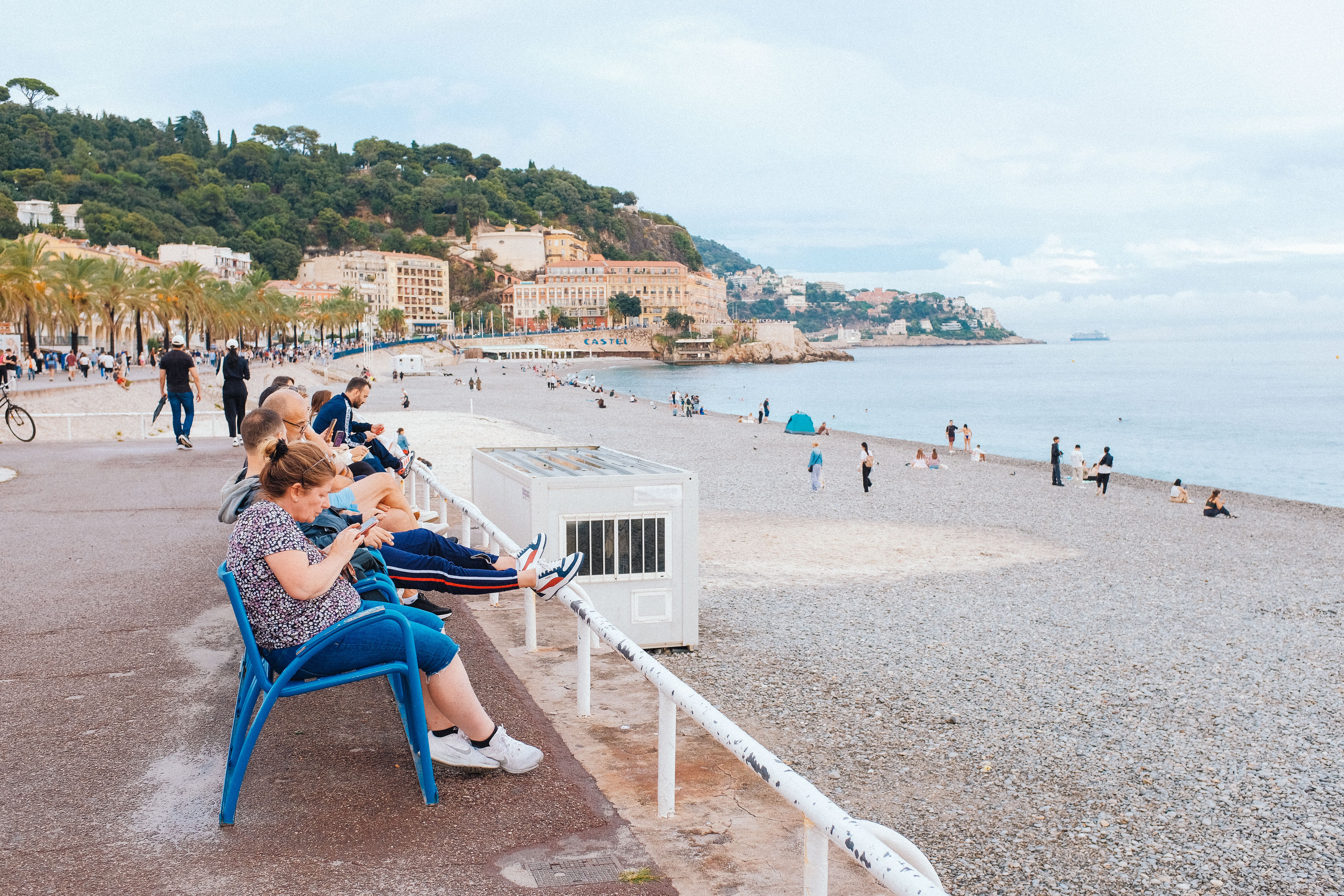 Coastal Promenade with People Relaxing by the Beach · Free Stock Photo