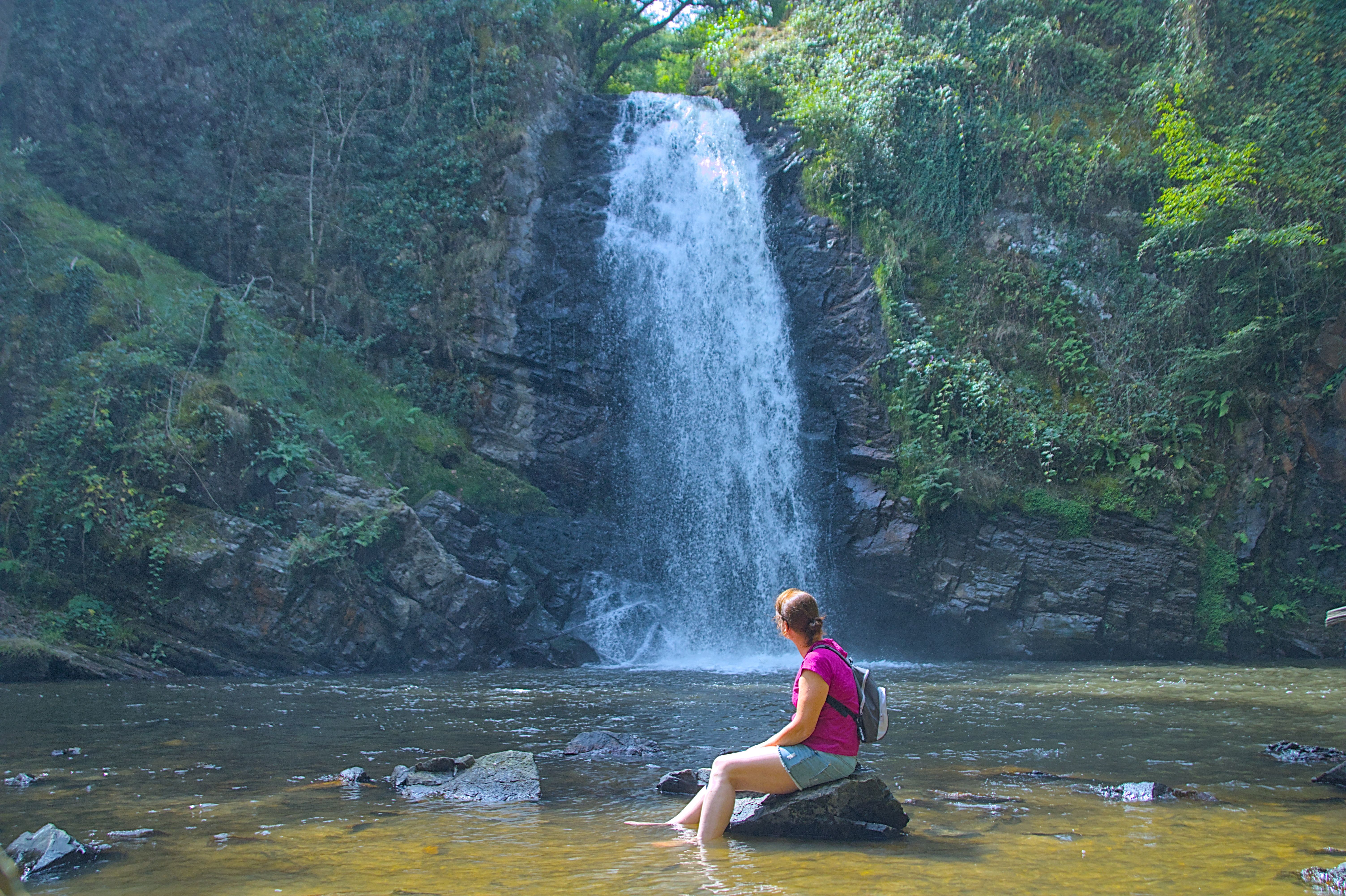 Woman Relaxing at Scenic Waterfall View · Free Stock Photo