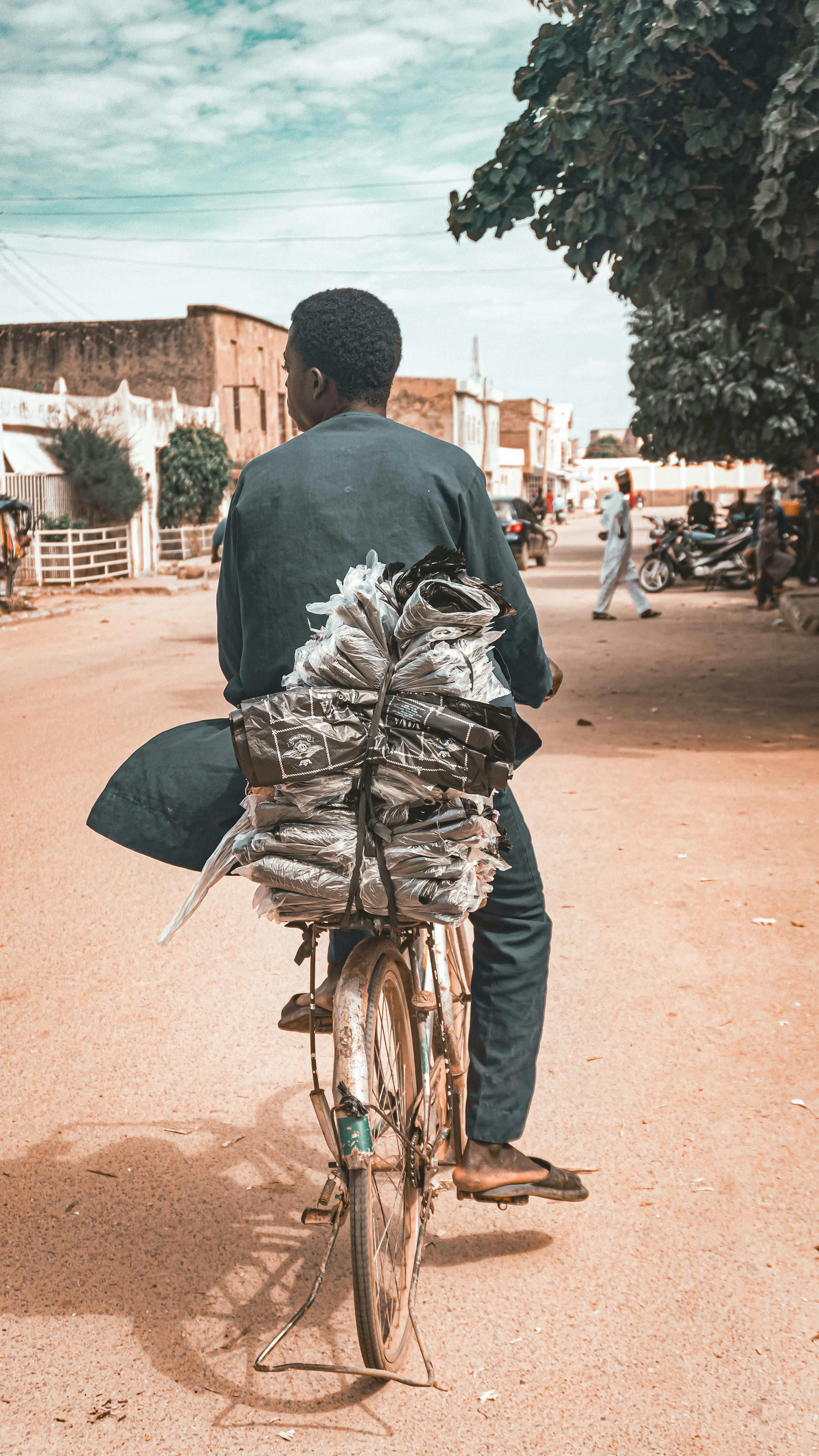 Man on Bicycle Selling Newspapers in Kano · Free Stock Photo
