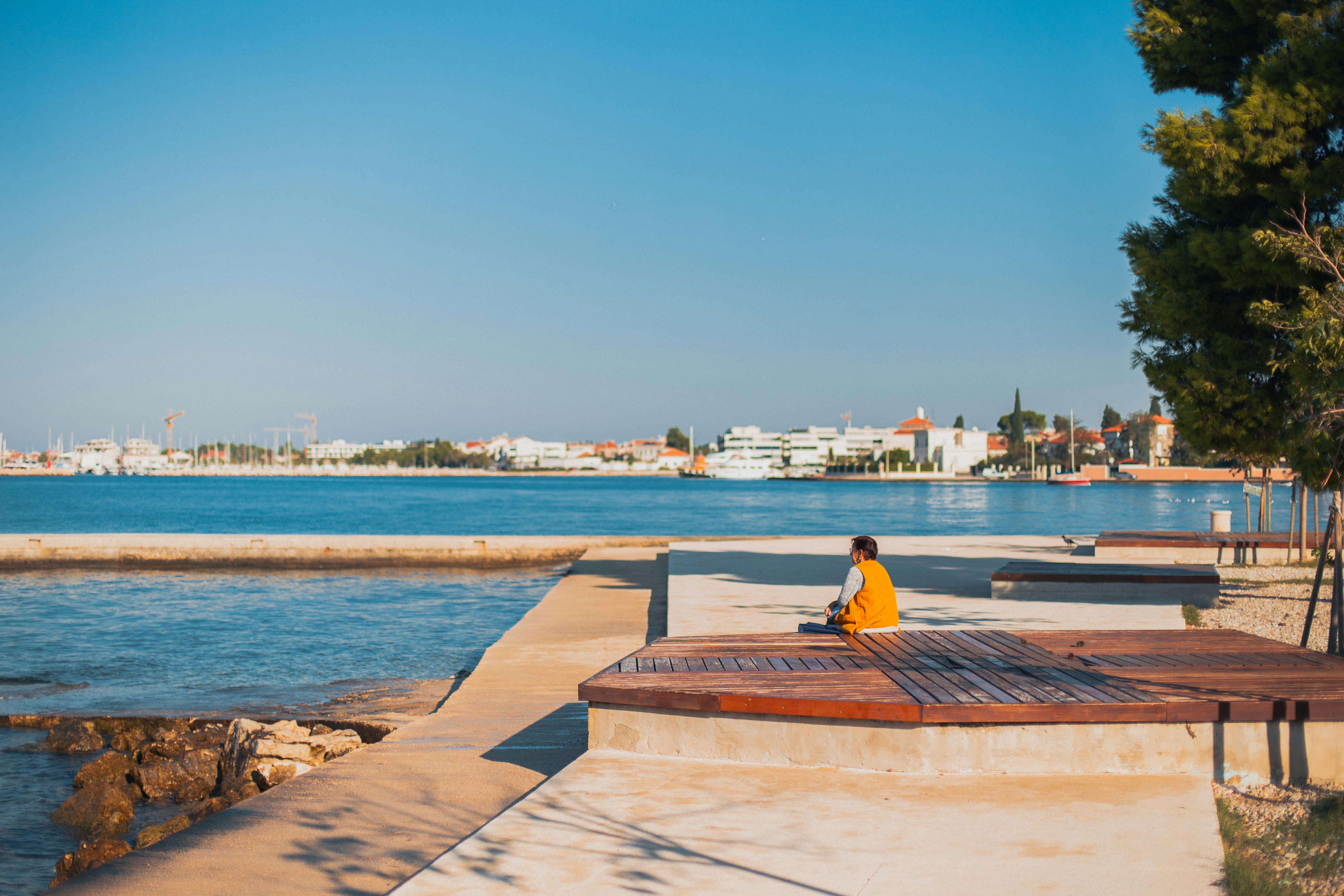 Serene Waterfront in Zadar with Relaxing Woman · Free Stock Photo