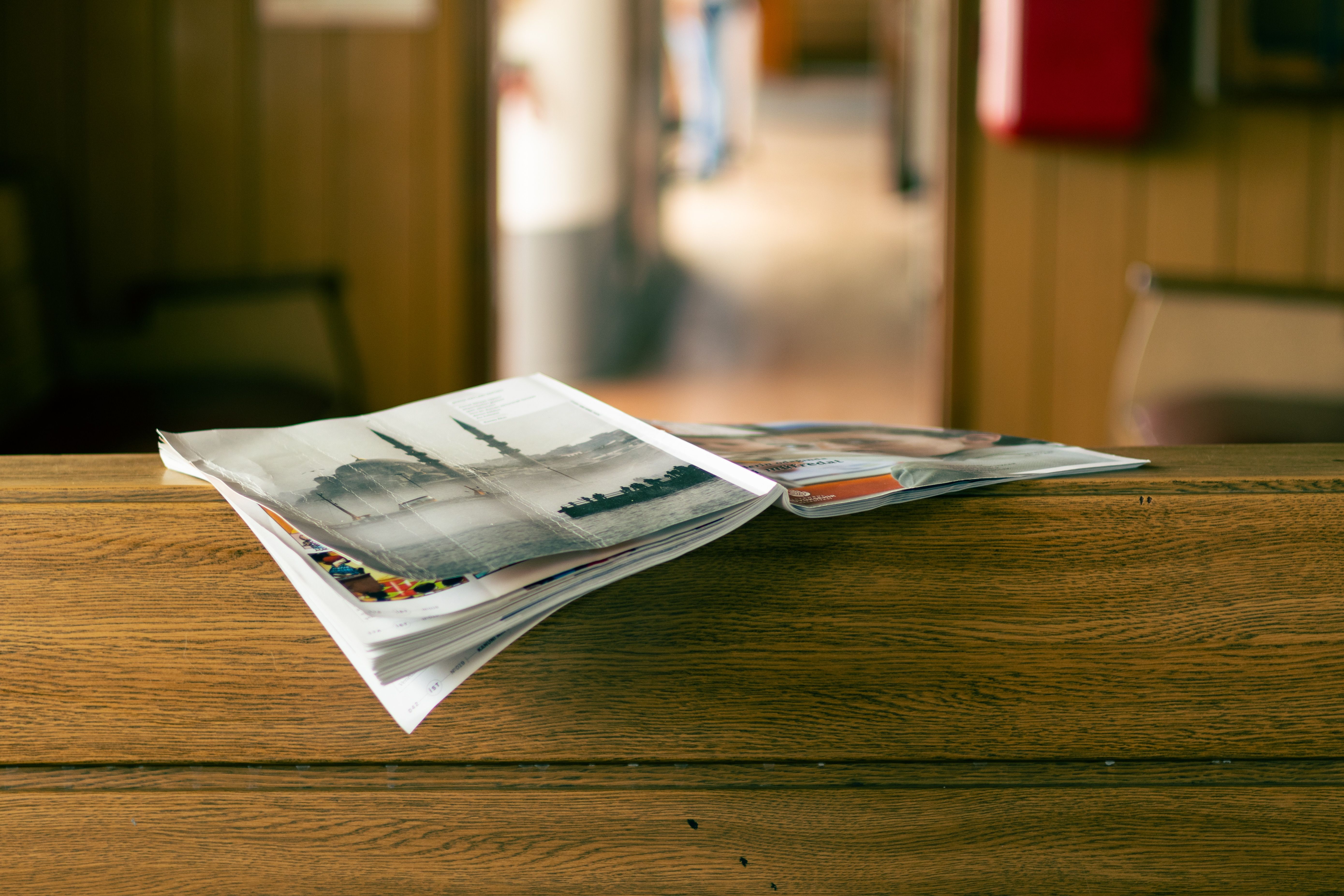 Magazines on Wooden Table in Cozy Setting · Free Stock Photo