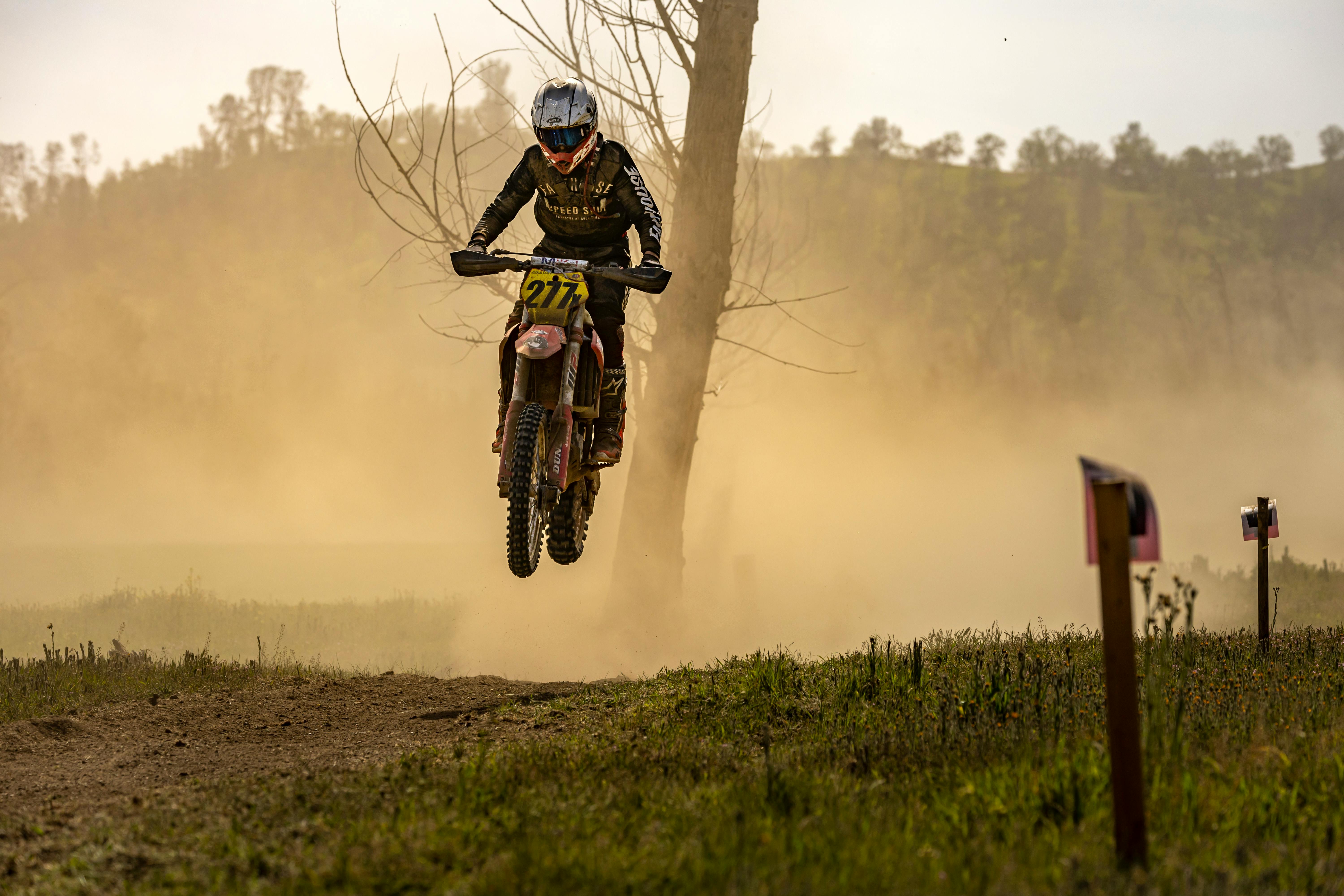 Thrilling Dirt Bike Jump in Dusty Landscape · Free Stock Photo
