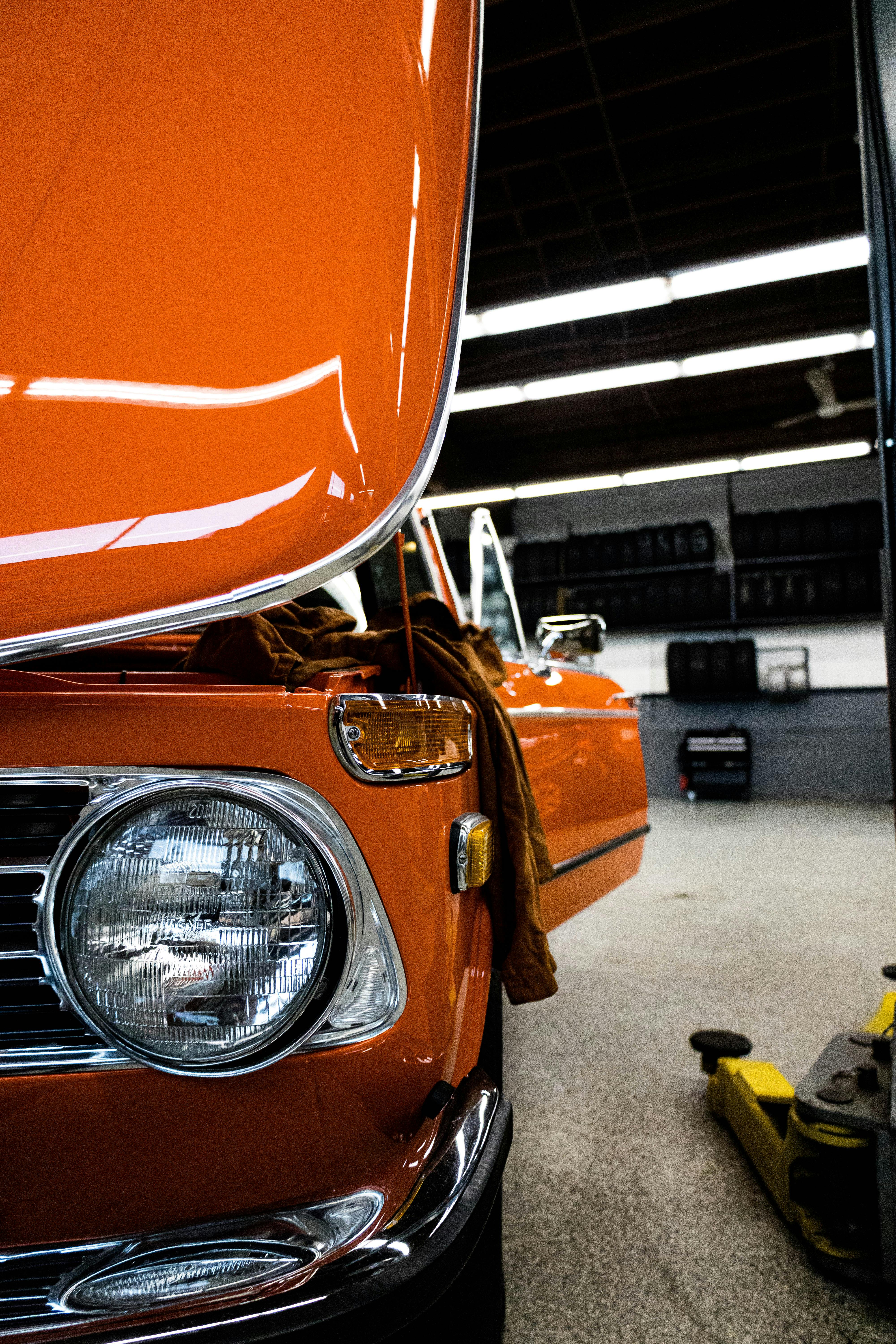 Vintage Orange Car in Garage Workshop Setting · Free Stock Photo