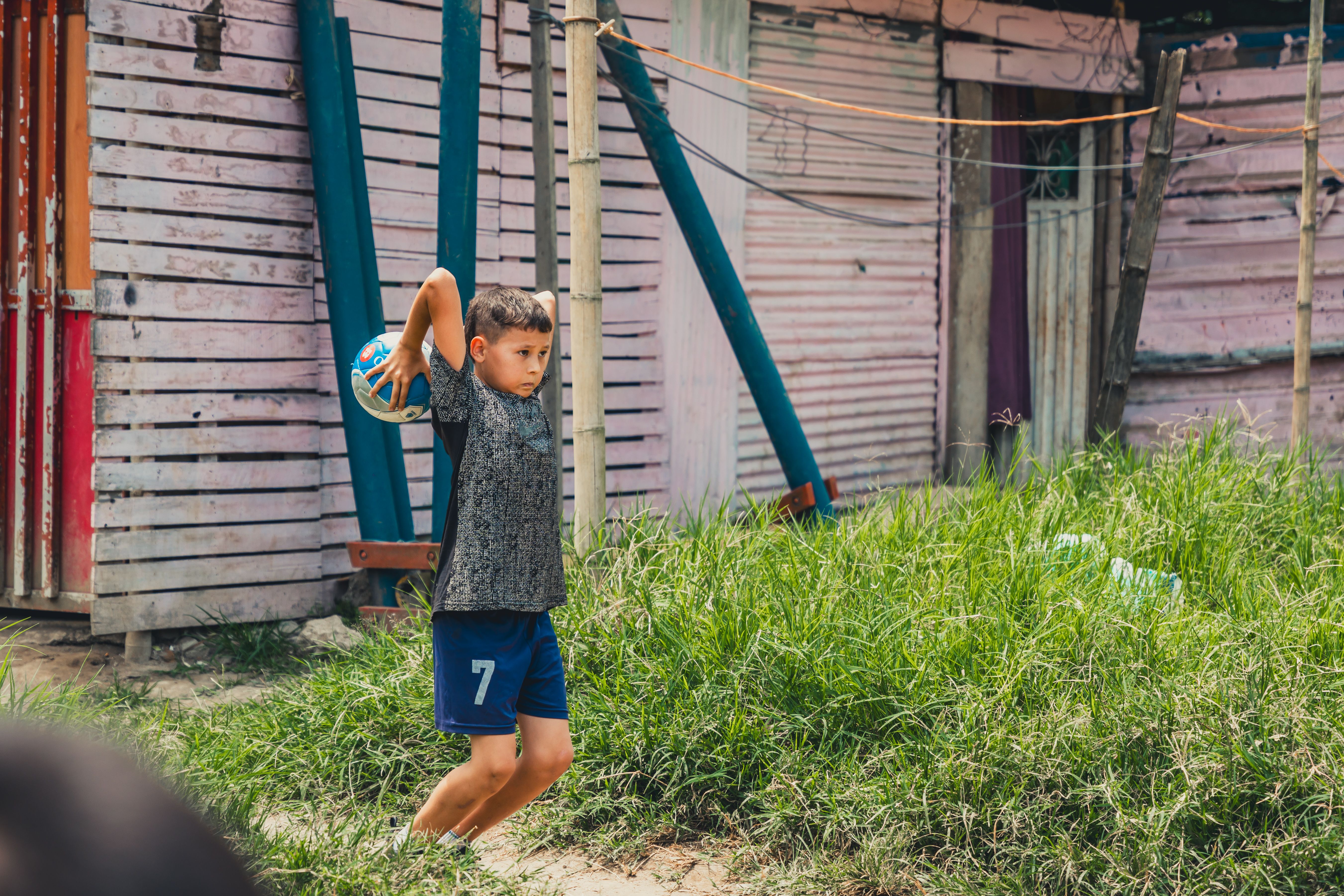 Boy Playing Soccer in Rustic Urban Setting · Free Stock Photo